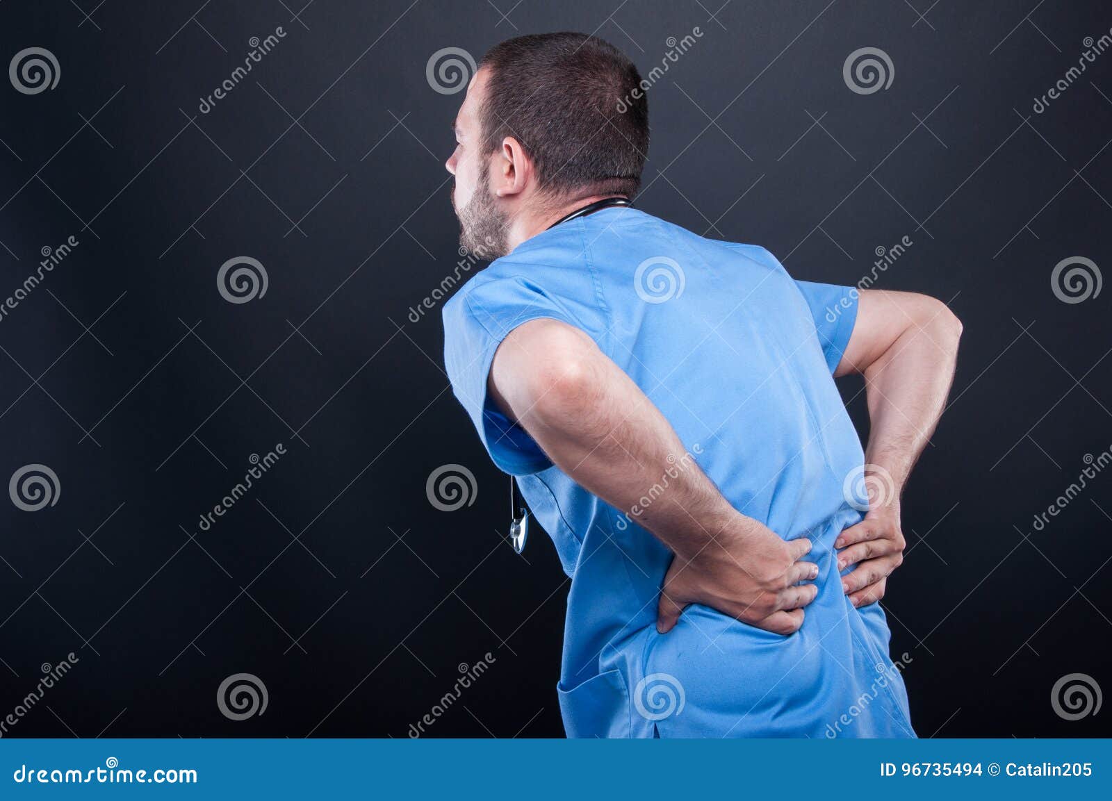 Young Doctor Wearing Scrubs Having Back Problem Stock Photo - Image of ...