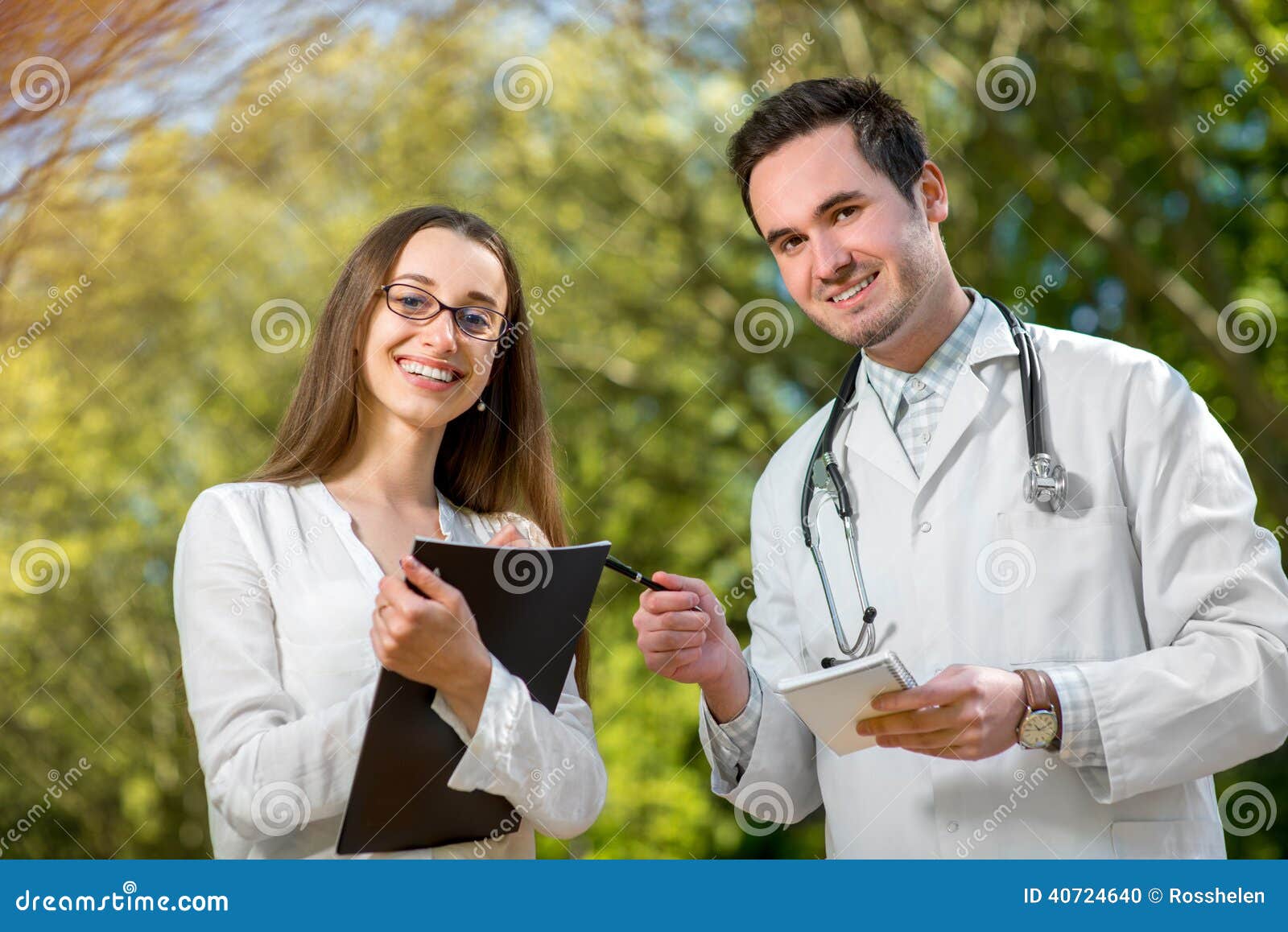 Young Doctor with Young and Pretty Assistant Speaking Stock Photo ...