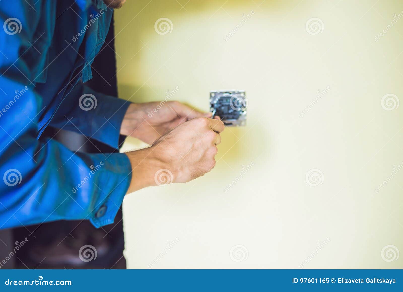A Young Electrician Installing an Electrical Switch in a New House ...