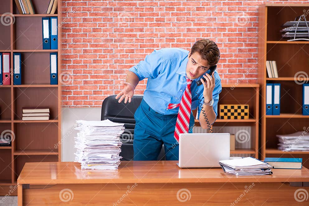 The Young Employee with Excessive Work Sitting at the Office Stock ...