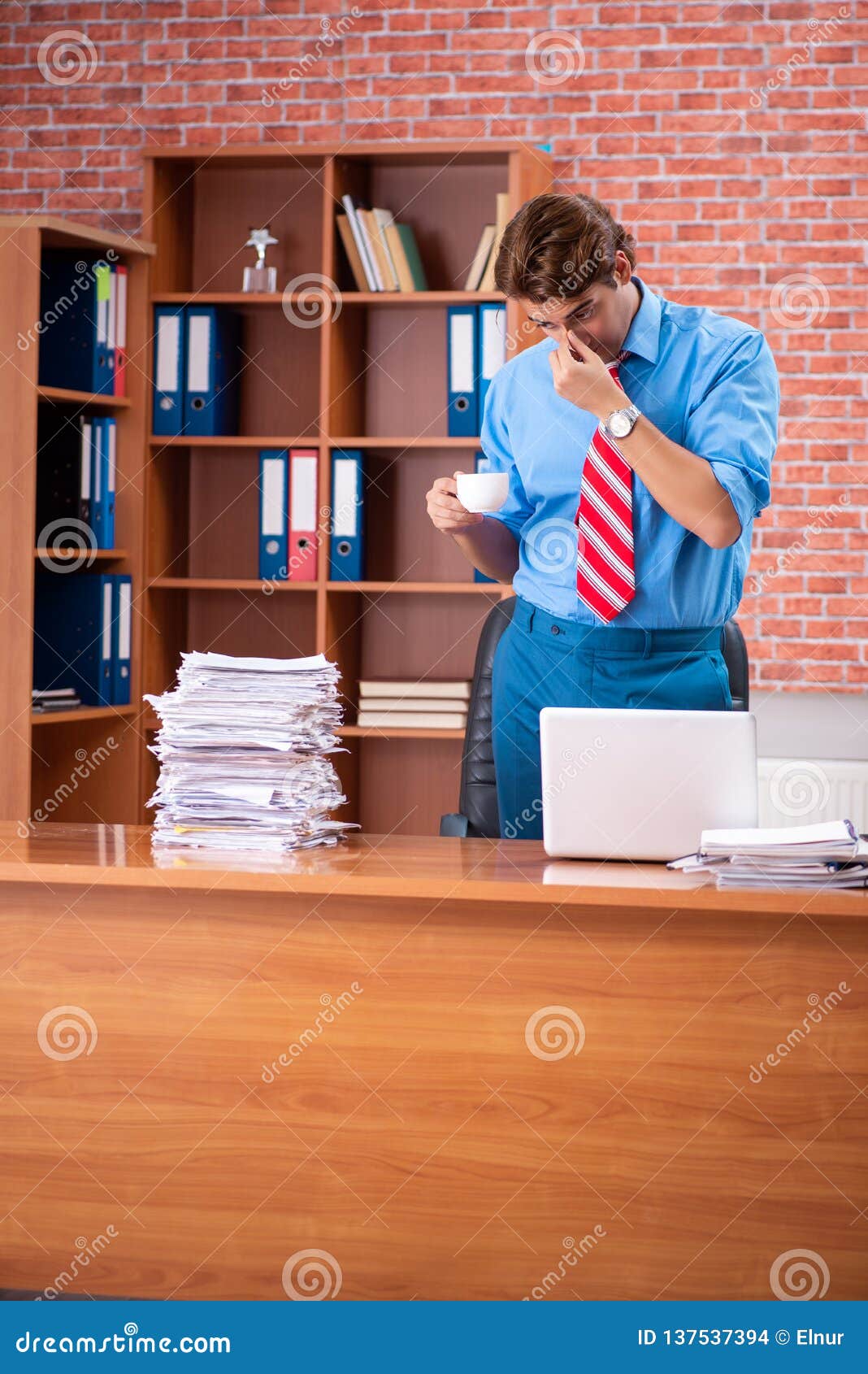 The Young Employee with Excessive Work Sitting at the Office Stock ...