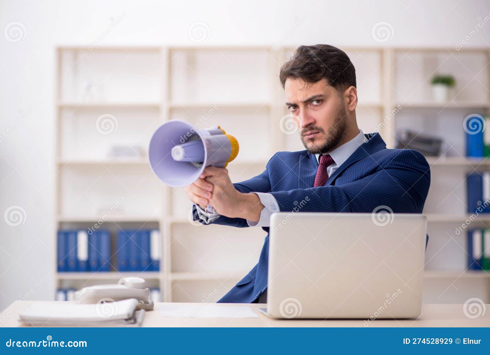 Young Male Employee Holding Megaphone at Workplace Stock Image - Image ...