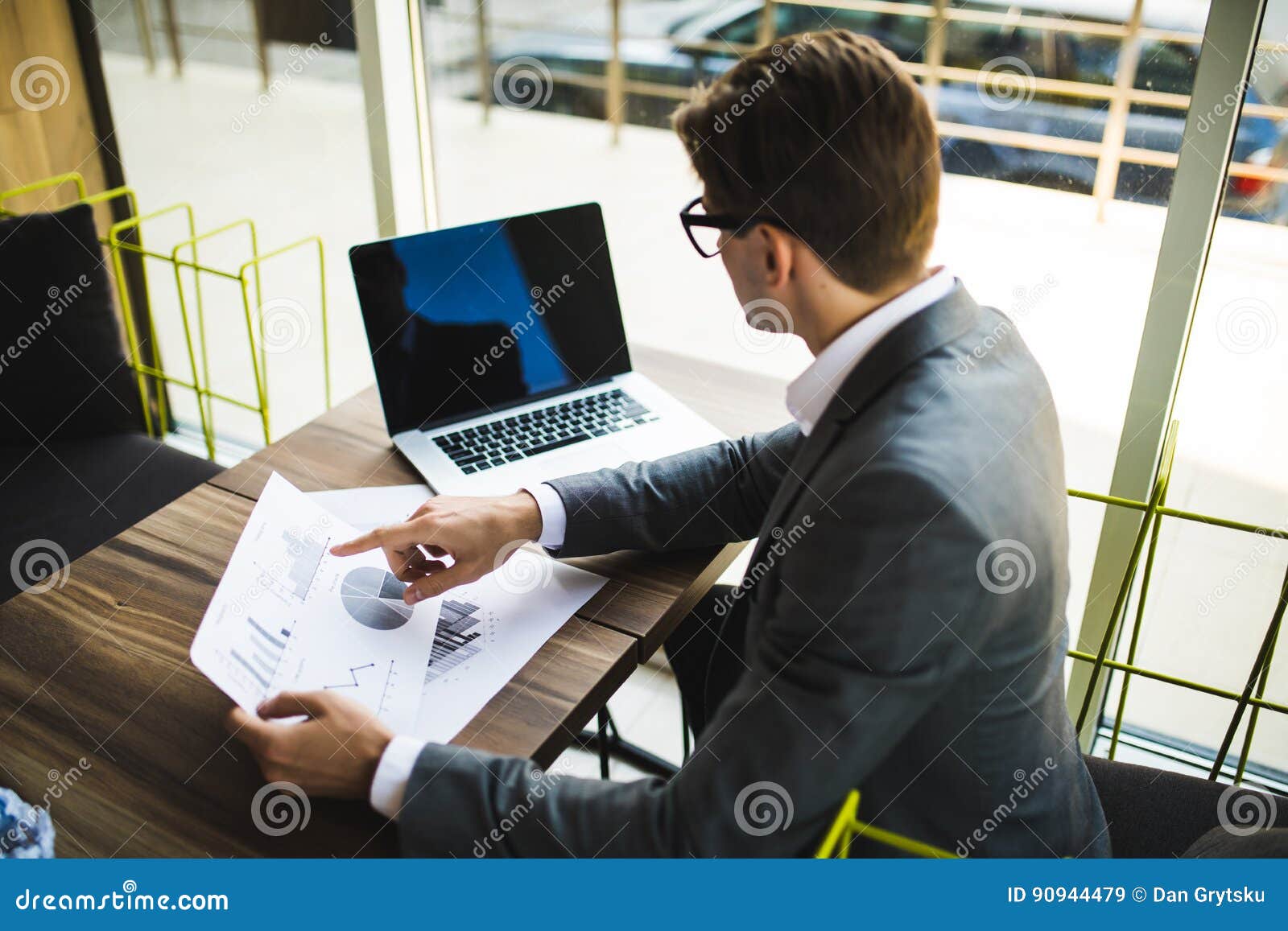 Young Employee Looking at Computer Monitor with Documents during ...