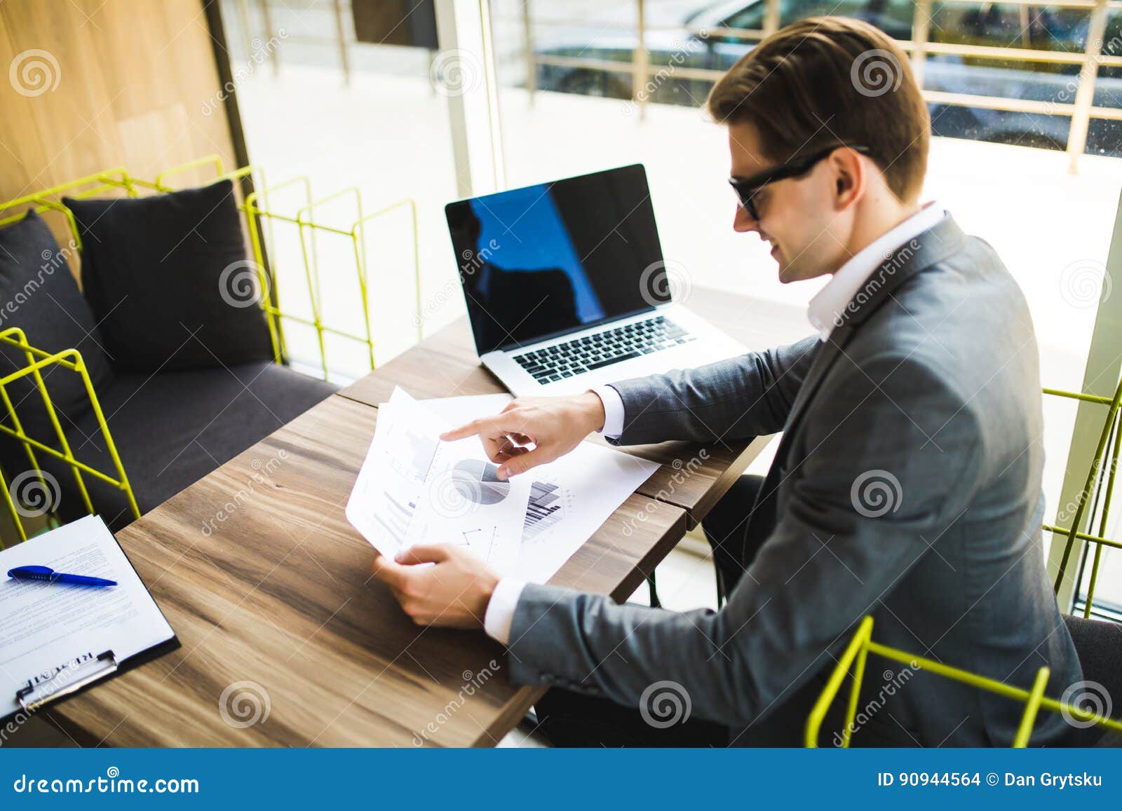 Young Employee Looking at Computer Monitor with Documents during ...