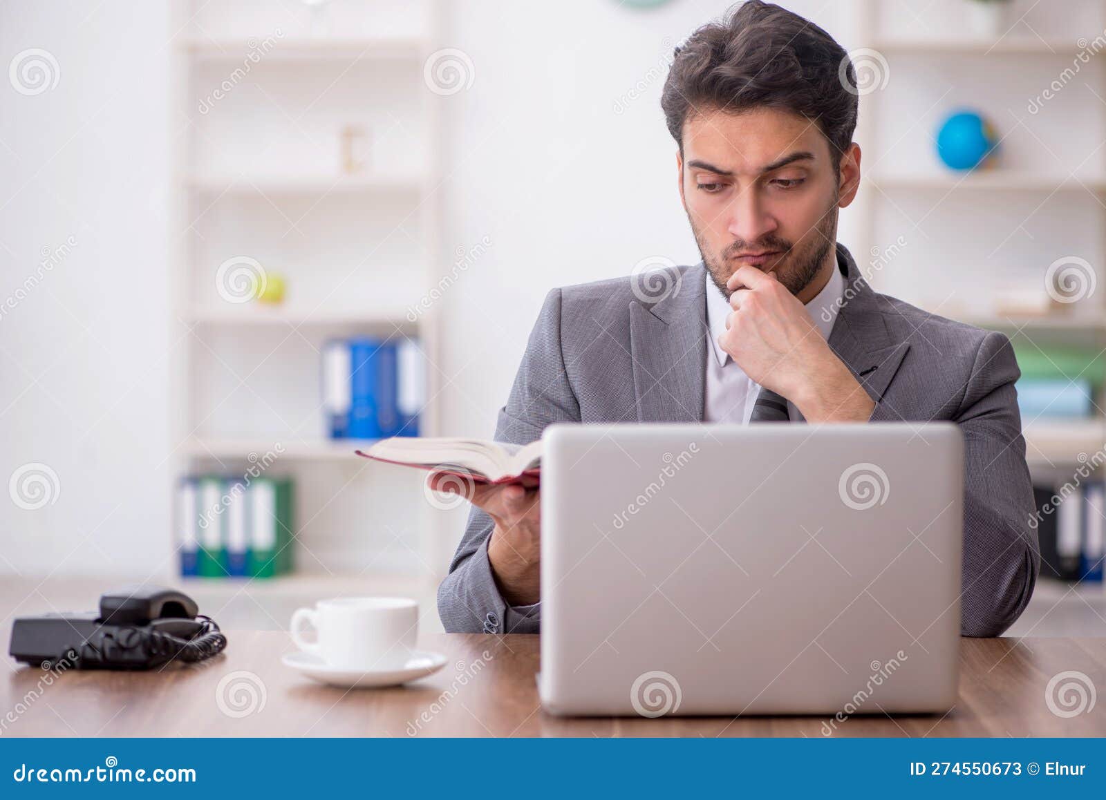 Young Male Employee Reading Book in the Office Stock Image - Image of ...