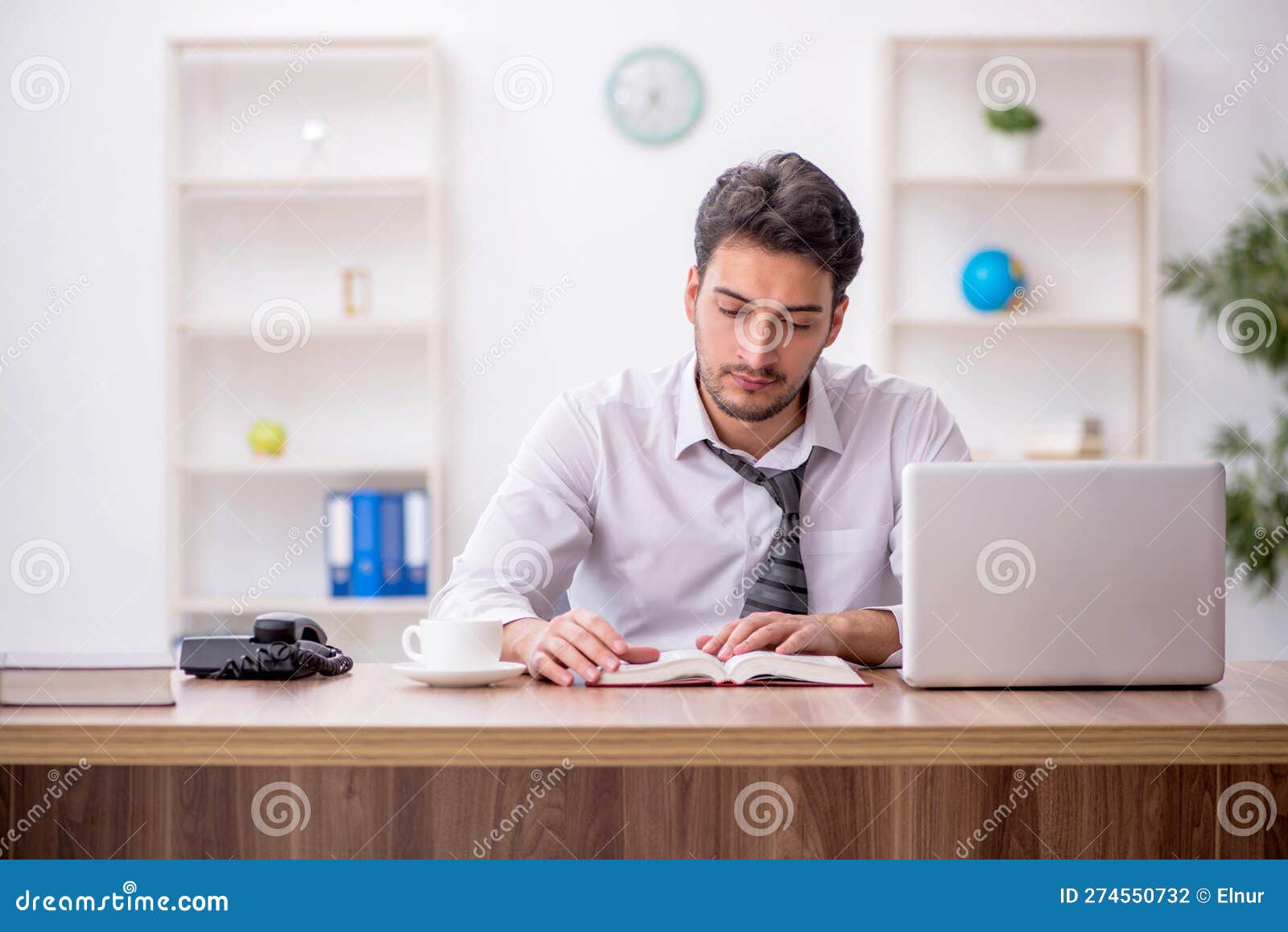 Young Male Employee Reading Book in the Office Stock Photo - Image of ...