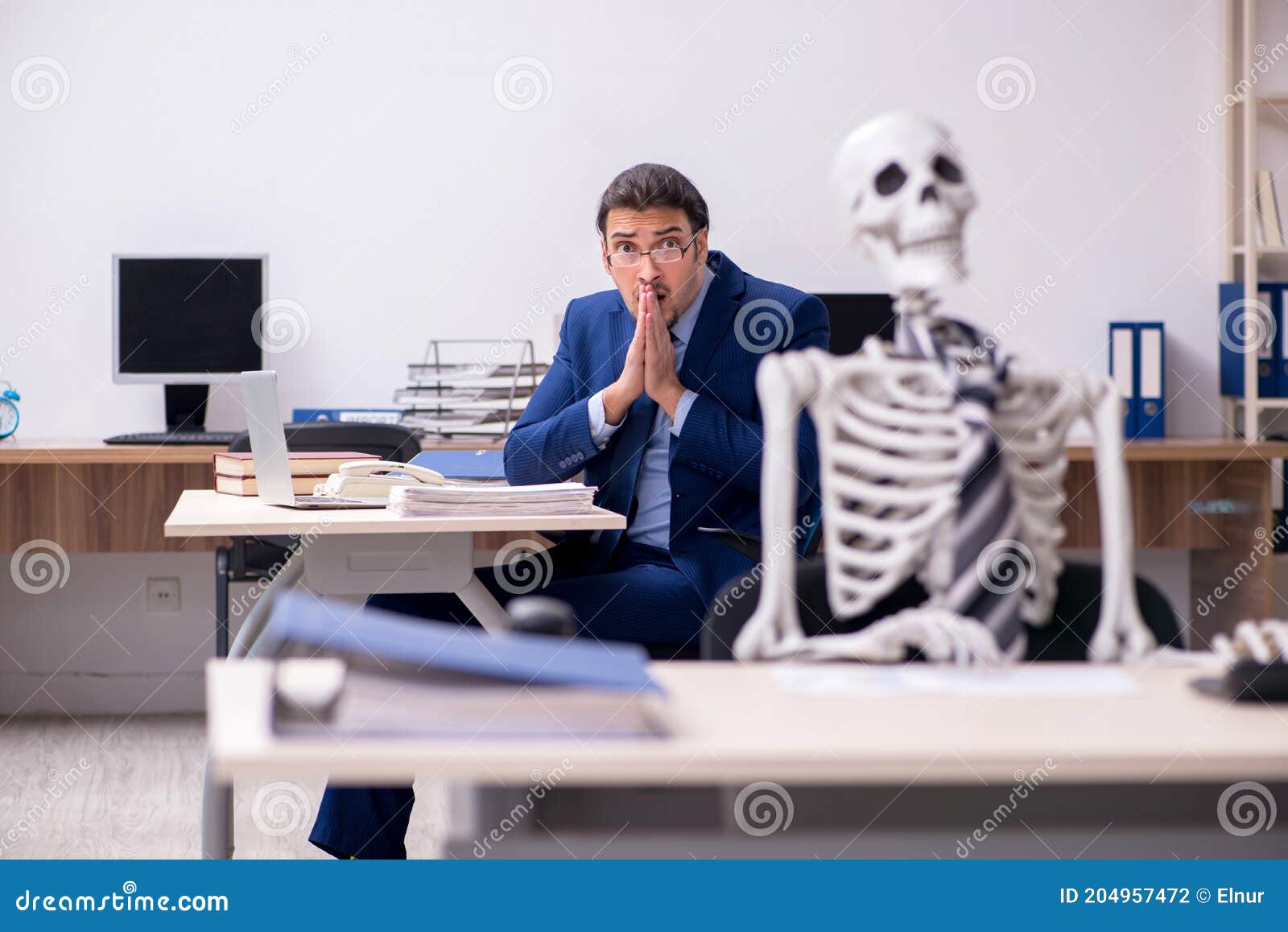 Young Male Employee with Skeletons in the Office Stock Photo - Image of ...