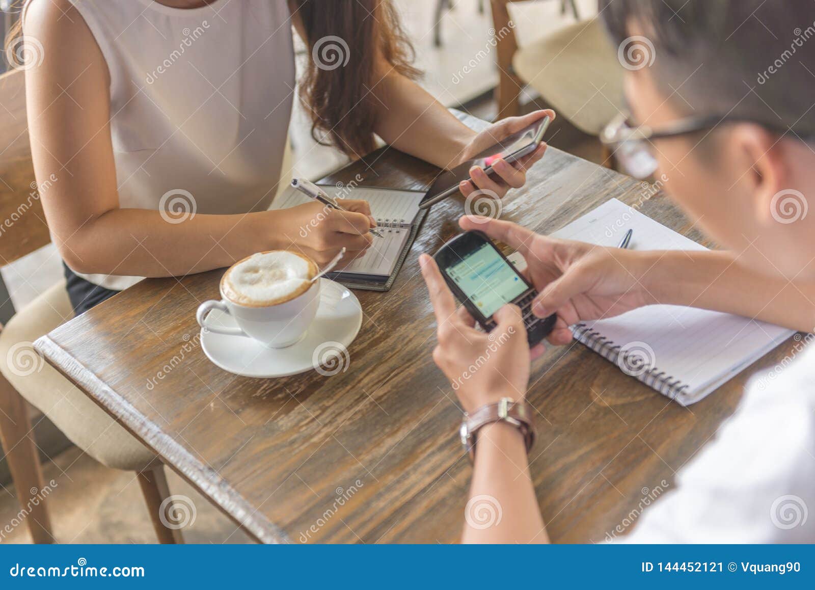 Young Employee Using Smartphone and Writing Notes Stock Image - Image ...