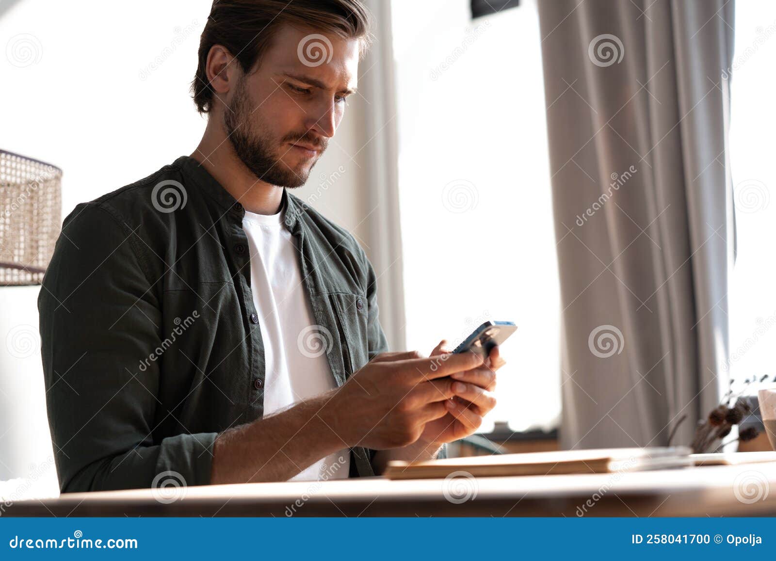 Young Employee at Workplace Using Mobile Phone, Checking Social Media ...