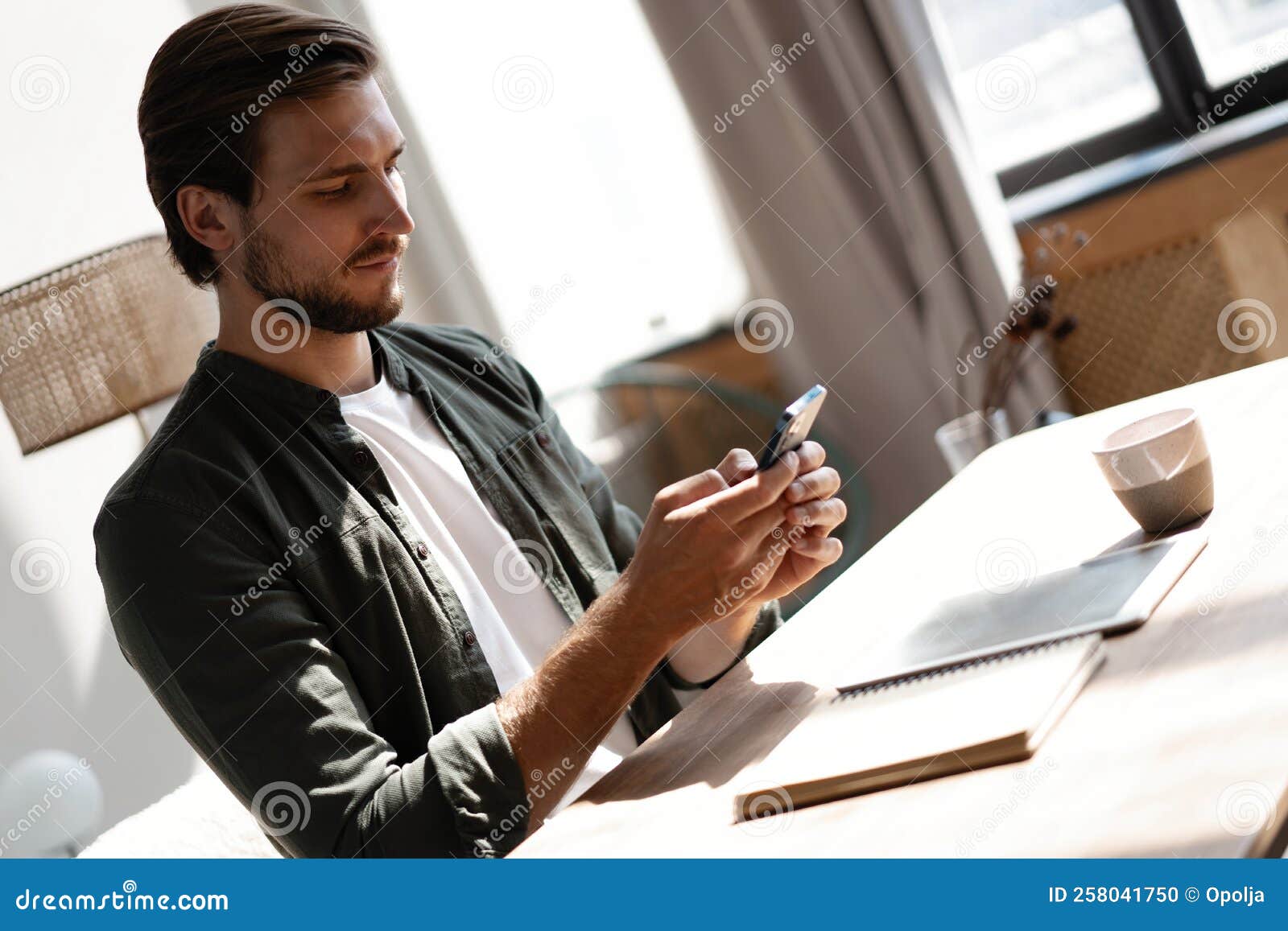 Young Employee at Workplace Using Mobile Phone, Checking Social Media ...