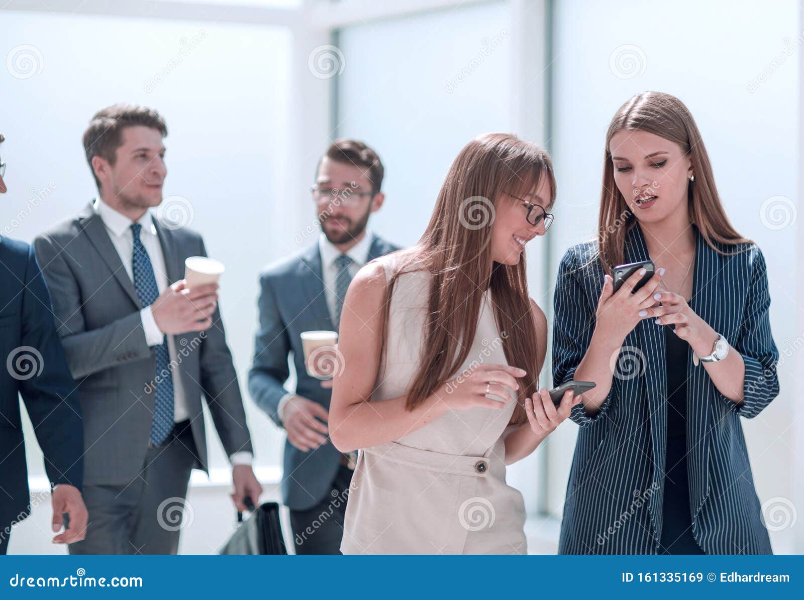 Young Employees Exchanging Information in the Office Lobby Stock Image ...