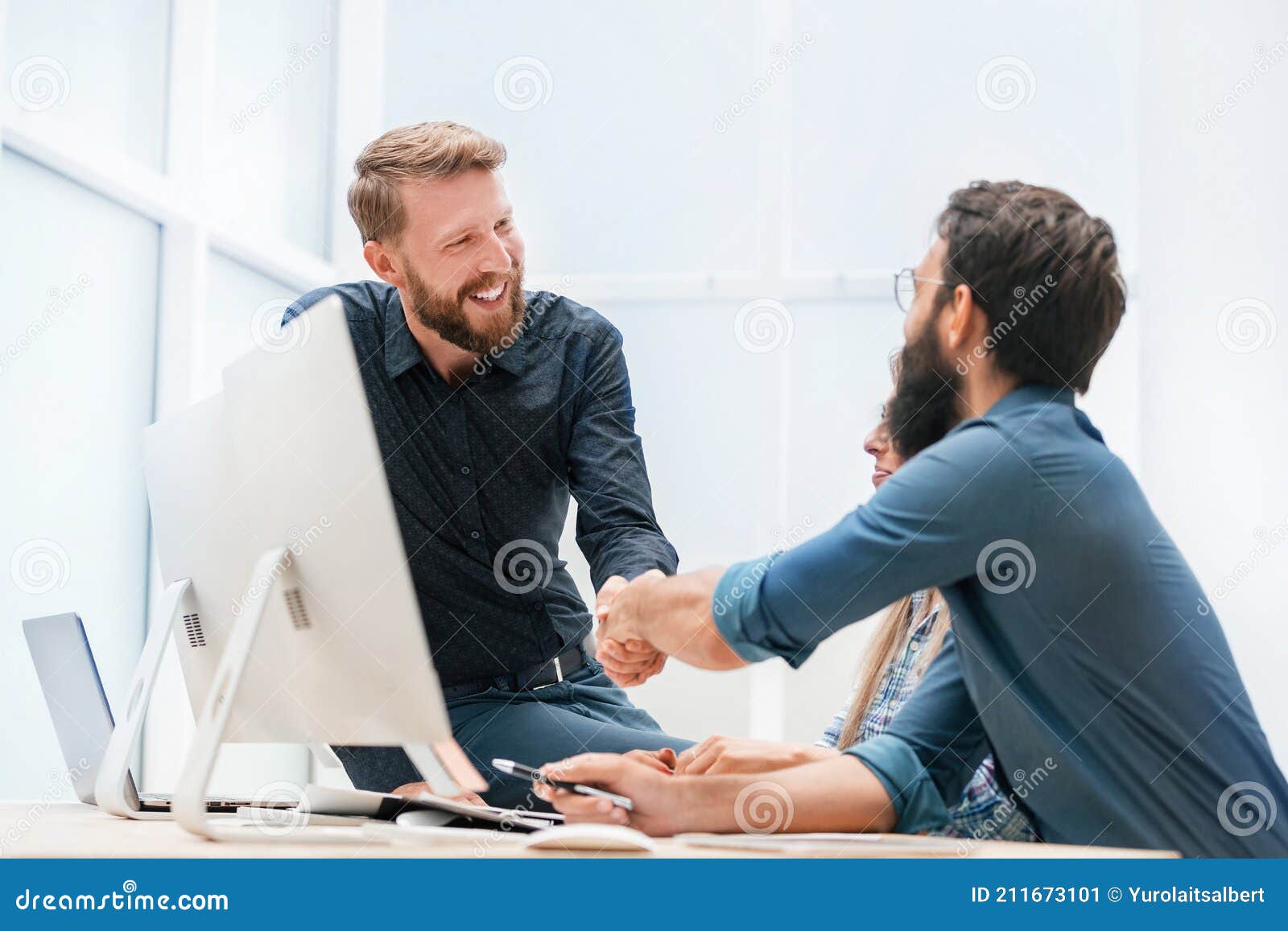 Young Employees Shaking Hands in the Workplace Stock Image - Image of ...