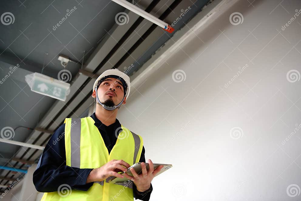 Young Engineer Apprentice Working with Technology Tablet in Survey and ...