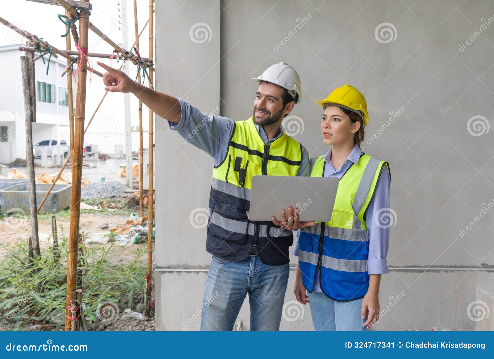 Young Engineer in a Construction Helmet and Safety Vest Explaining To ...