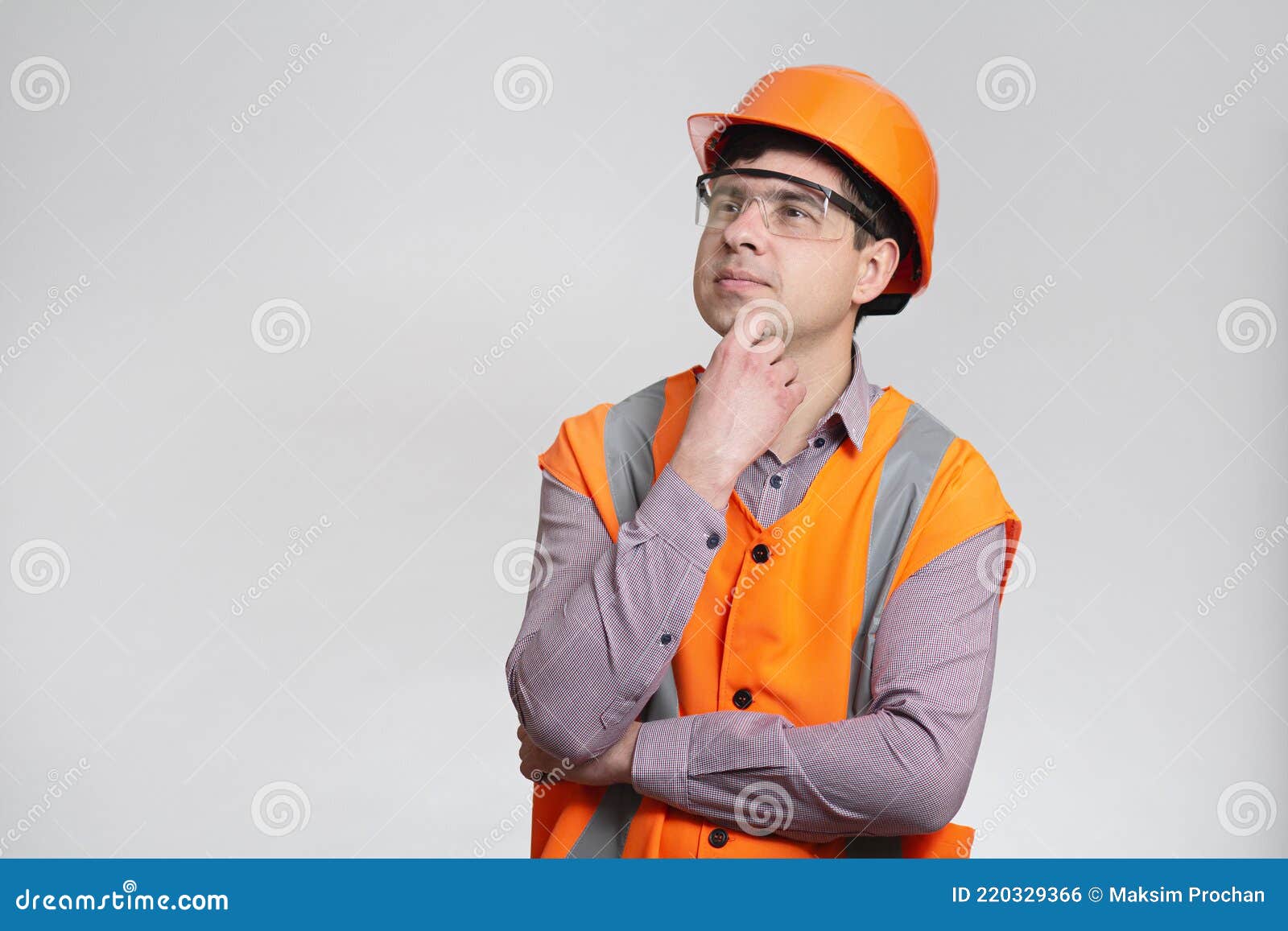 Young Engineer In Hard Hat And Reflective Vest Thinking On Grey Studio ...