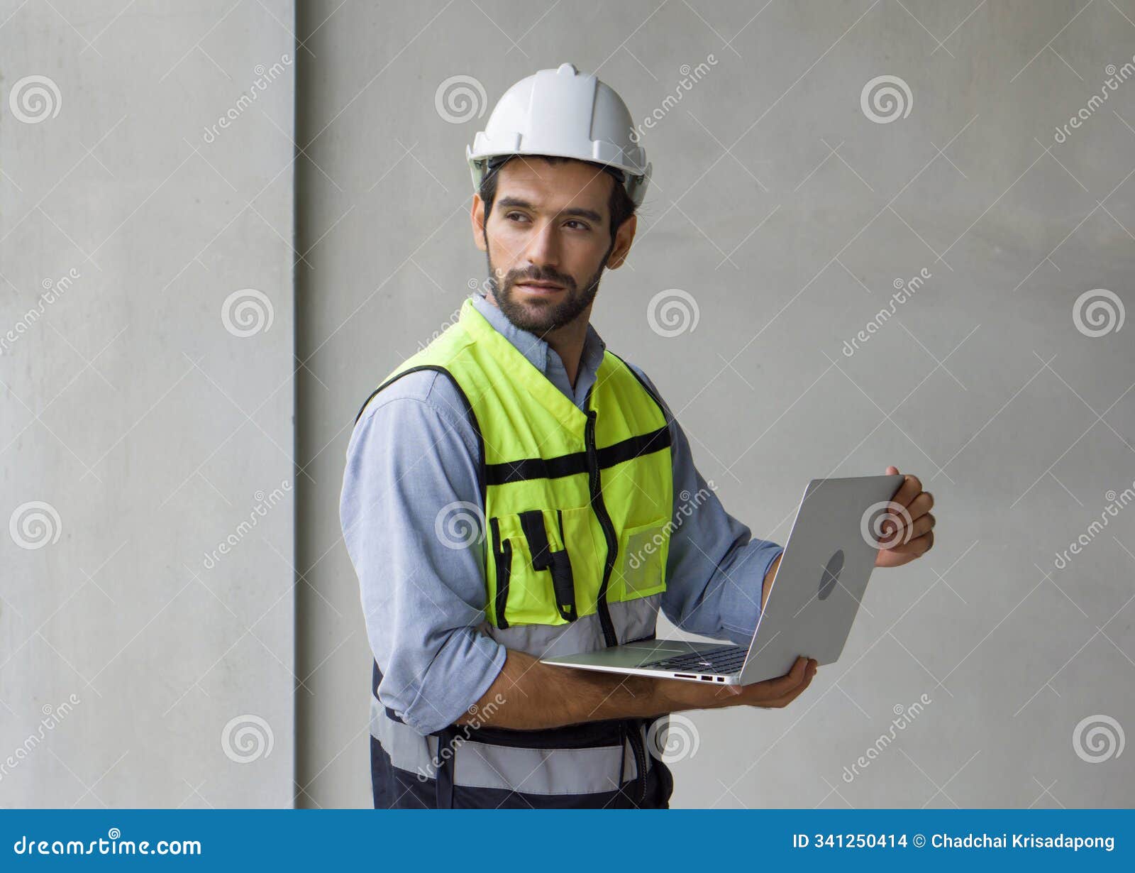 Young Engineer in Hardhat and Safety Vest Holding Laptop Computer Stand ...