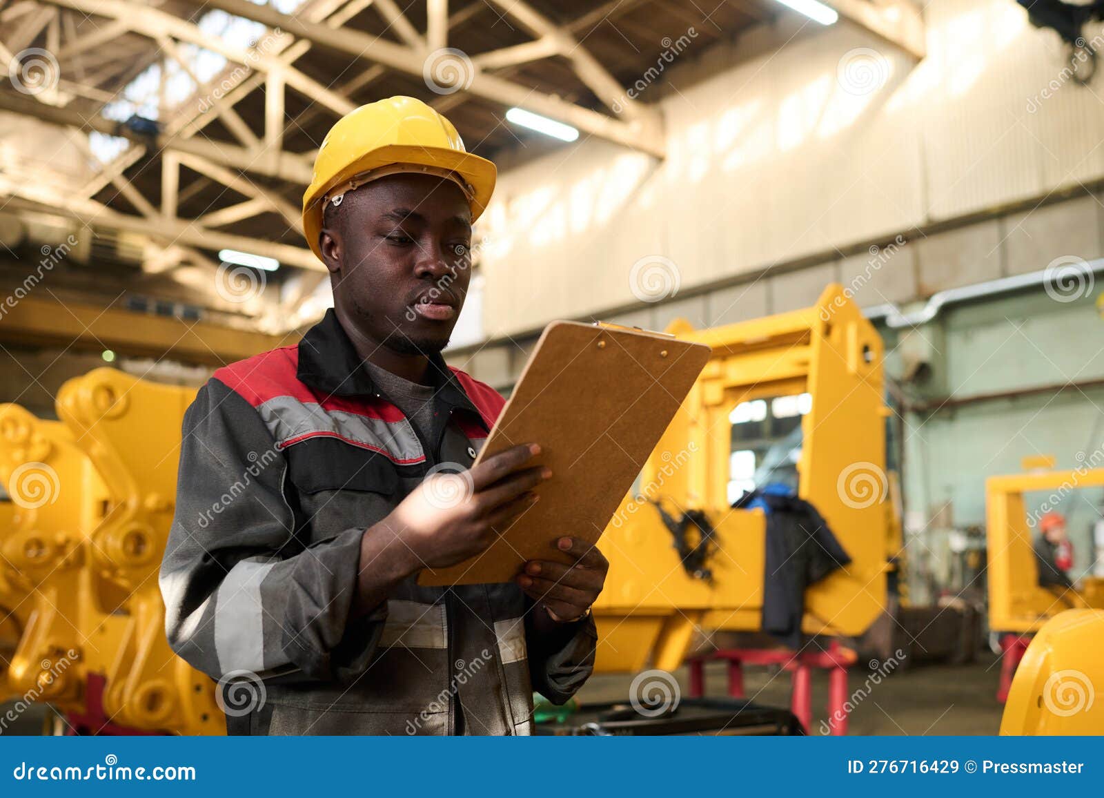 Young Engineer in Hardhat and Workwear Looking through Instruction ...