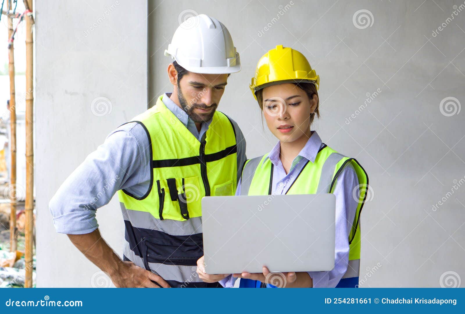 Young Engineer with Laptop Computer Explain To Foreman about a Floor ...