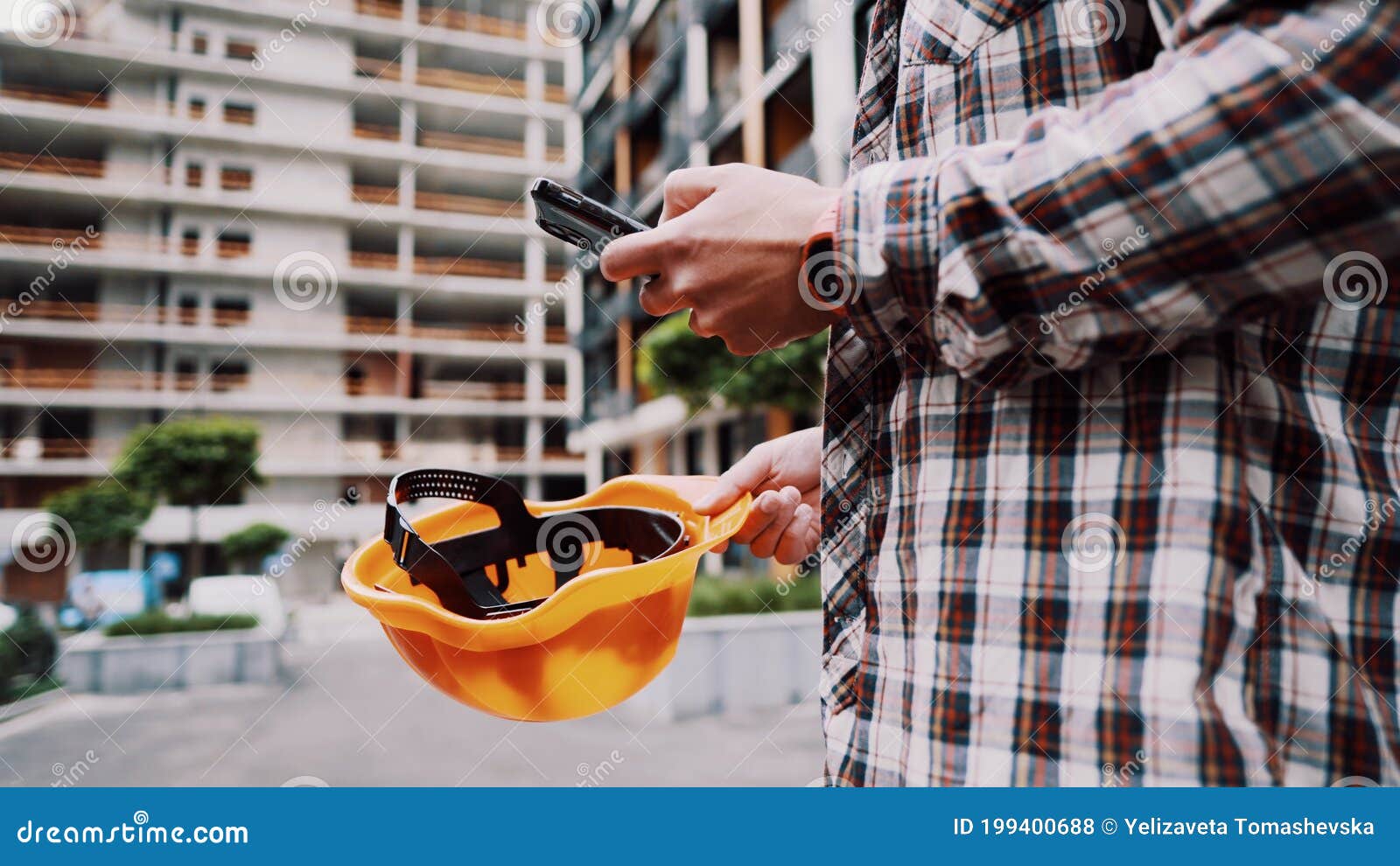 Young Engineer Using Smartphone on Construction Site. Architect Using ...