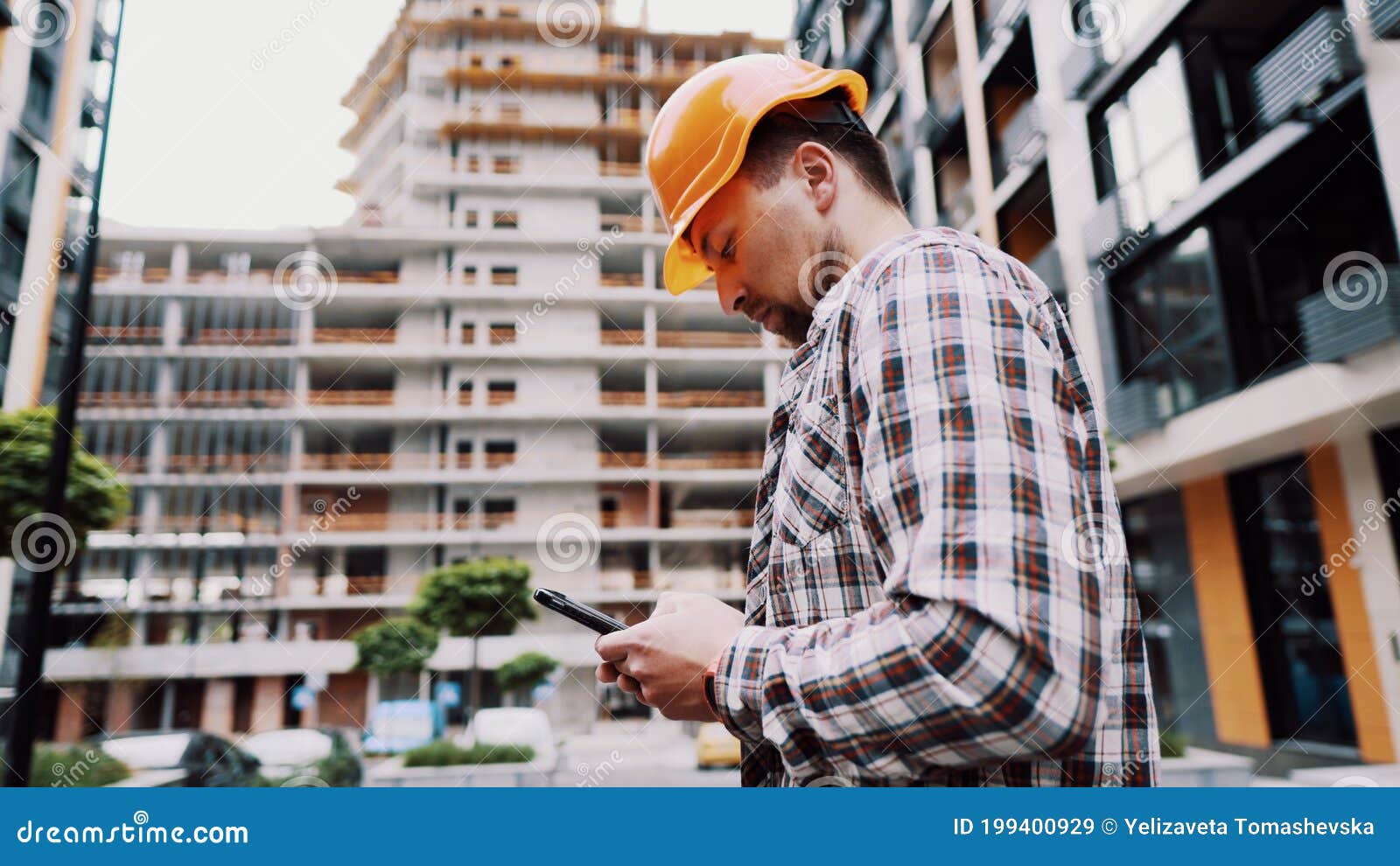 Young Engineer Using Smartphone on Construction Site. Architect Using ...
