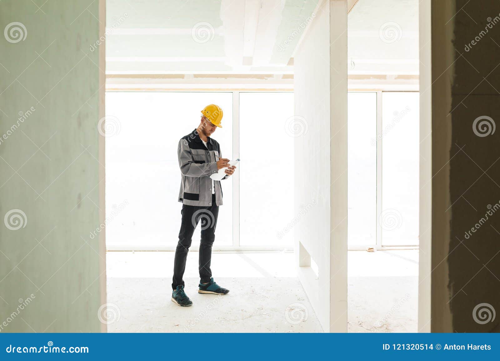 Young Engineer in Work Clothes and Yellow Hardhat Working with P Stock ...