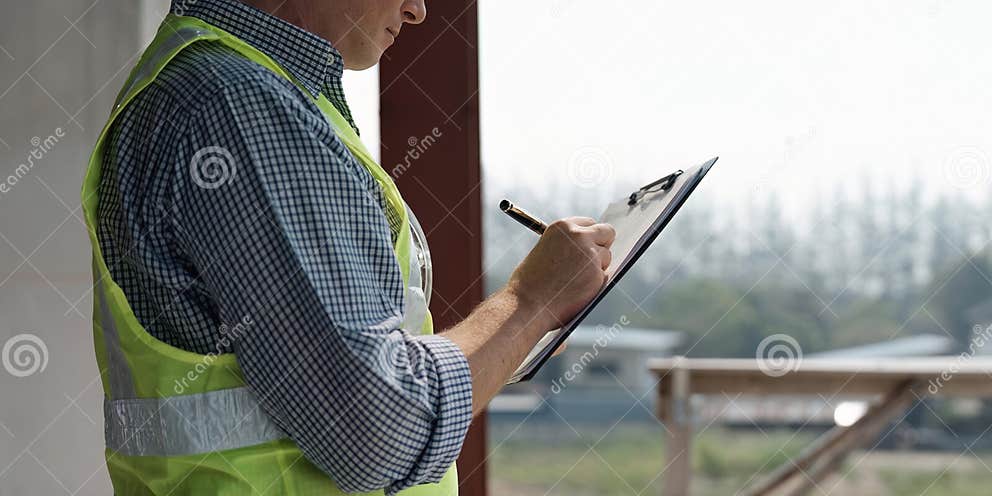 Young Engineering, Looking at Paperwork on the Inspecting the ...