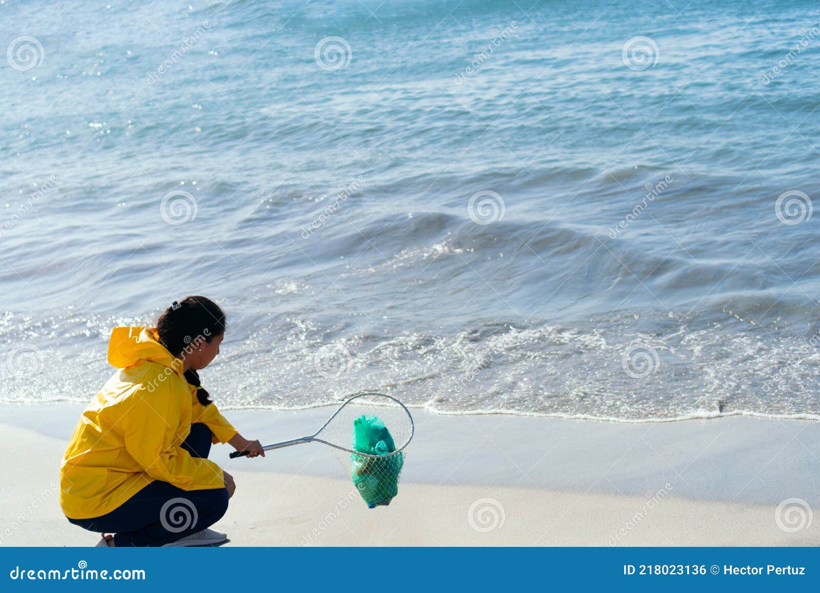 Young Environmentalist Collecting Plastics with a Net at the Beach ...