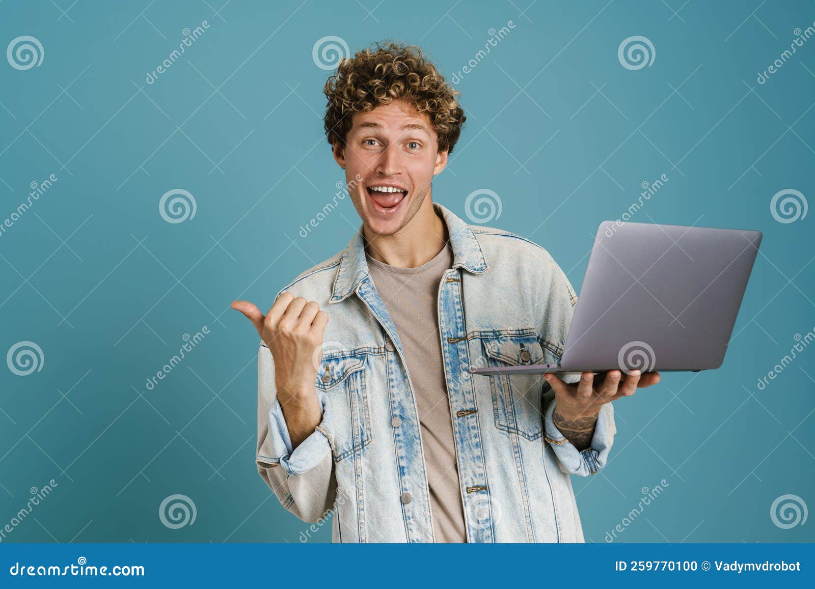 Young Excited Man Using Laptop while Pointing Finger Aside Stock Photo ...