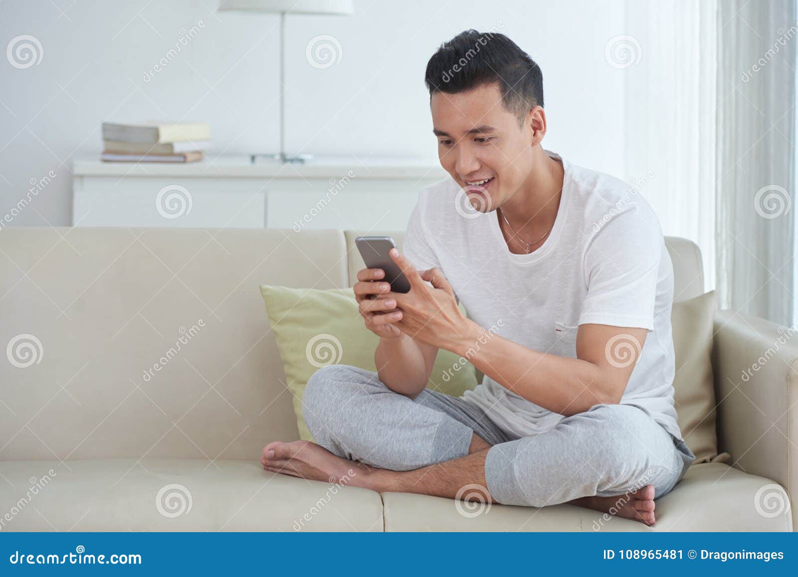 Man using mobile app stock image. Image of sofa, young - 108965481