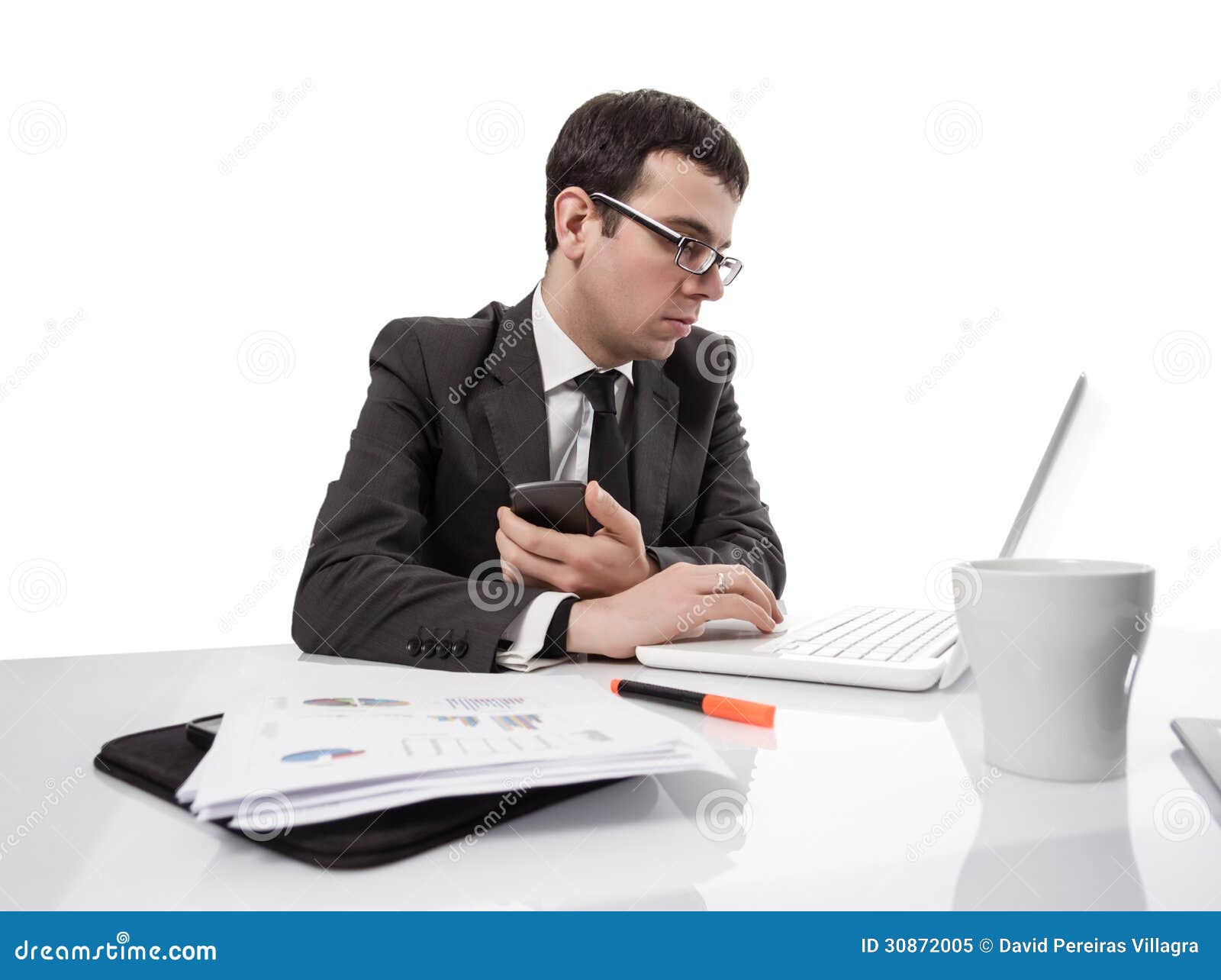 Young Executive Man Working on Laptop Computer and Holding a Smartphone ...