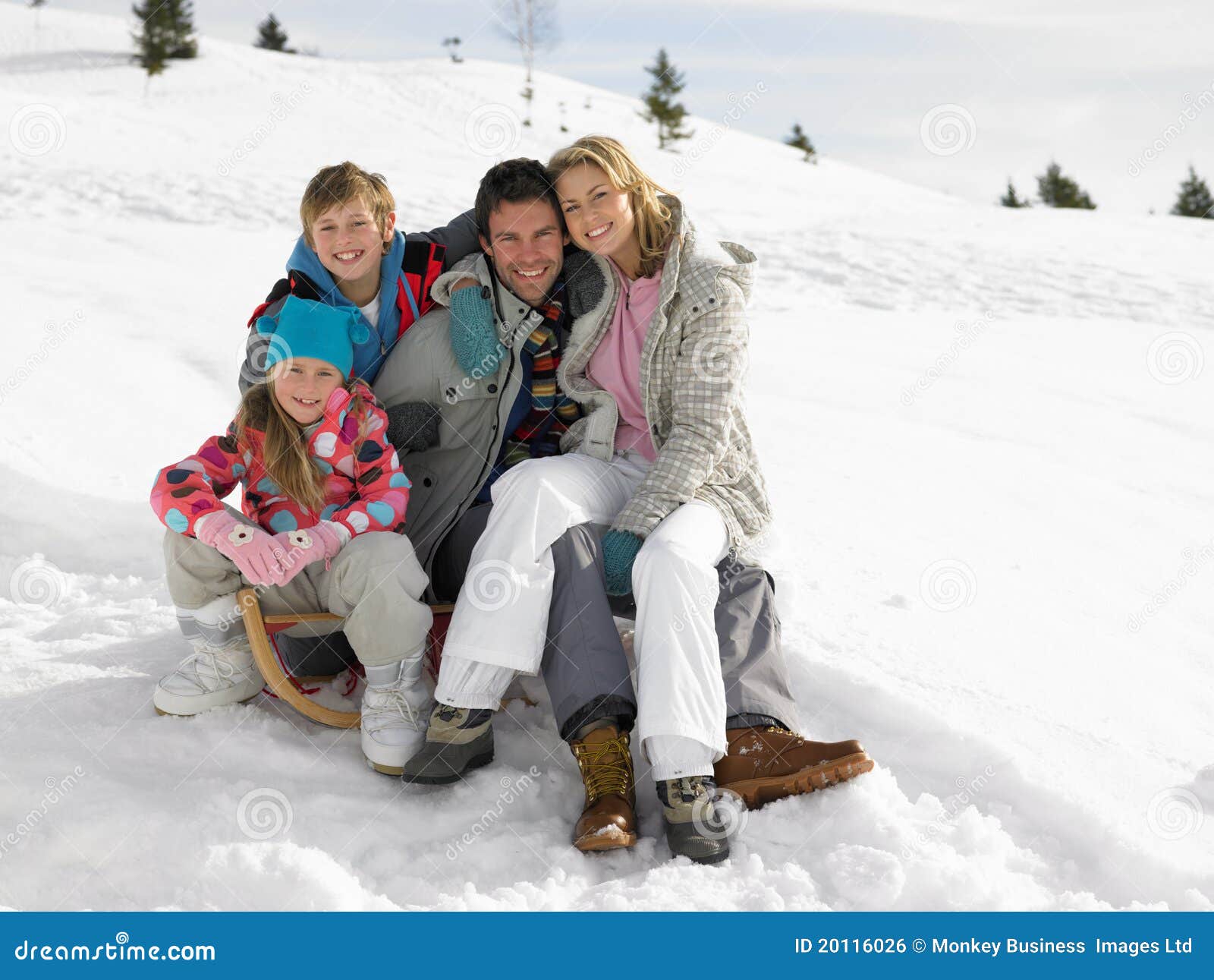Young Family Sitting on a Sled in the Snow Stock Photo - Image of knee ...