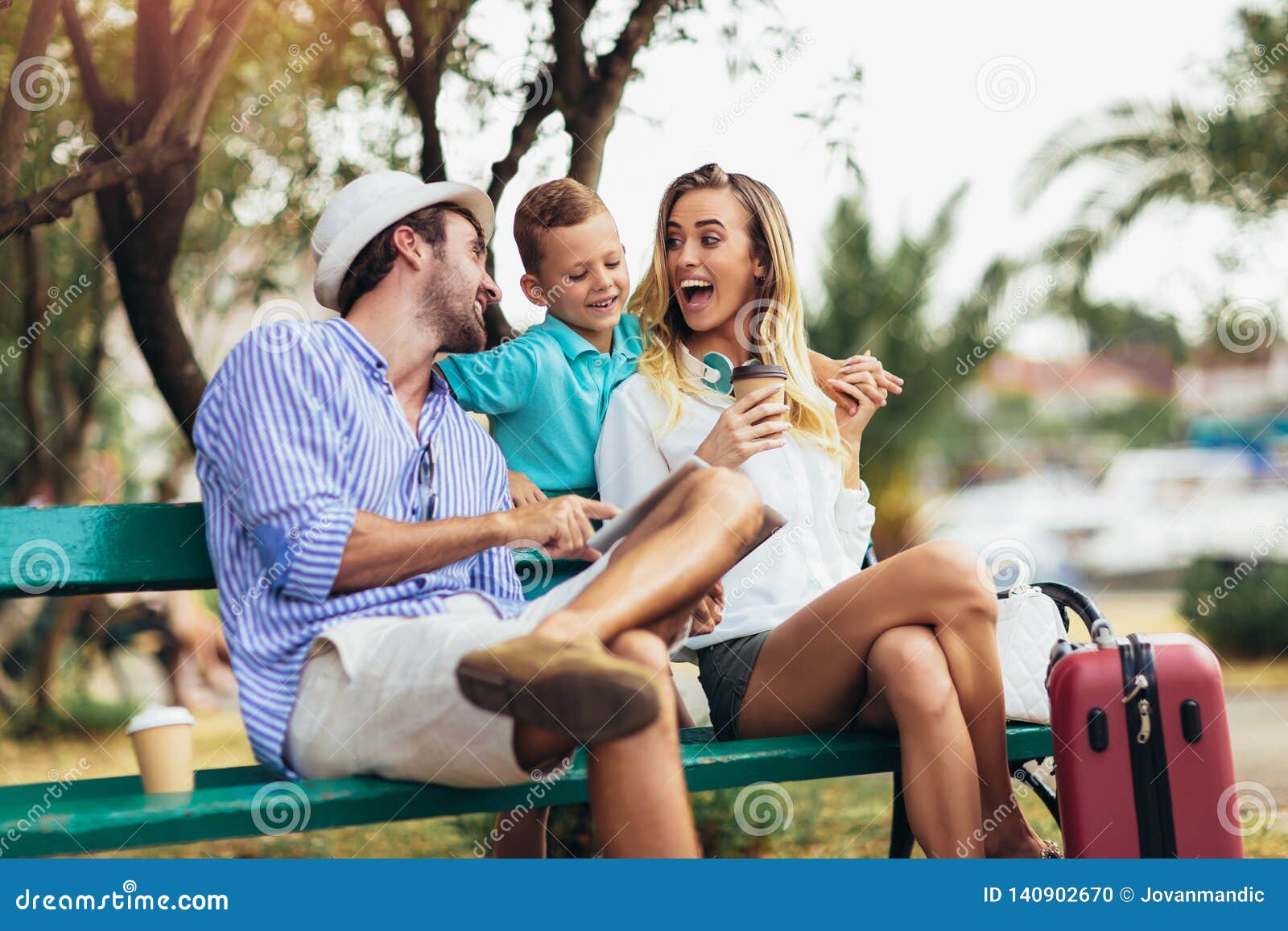 Family Talking and Looking at Digital Tablet in Park Stock Photo ...