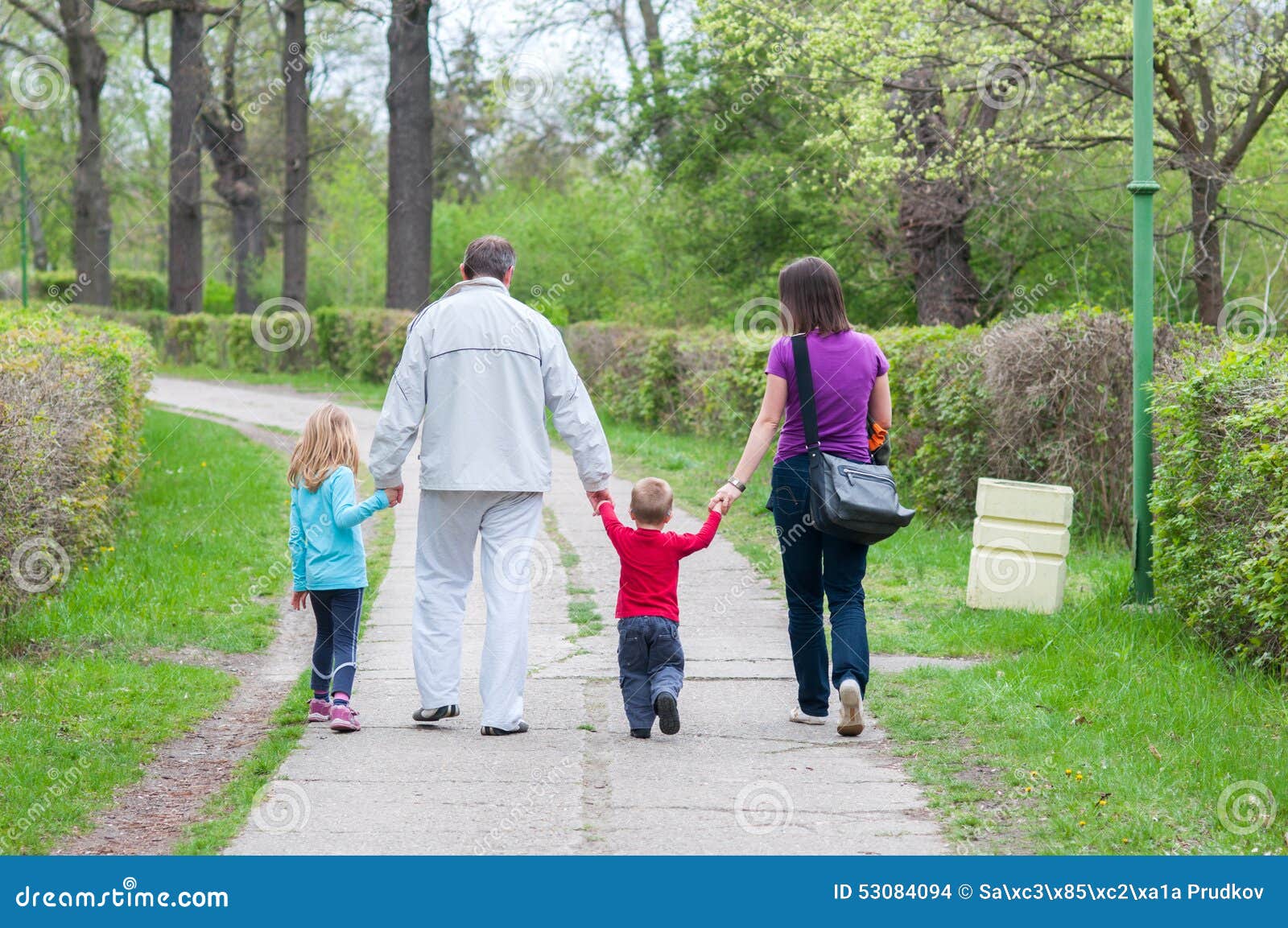 Young Family Walking in Park on Beautiful Spring Day Stock Photo ...