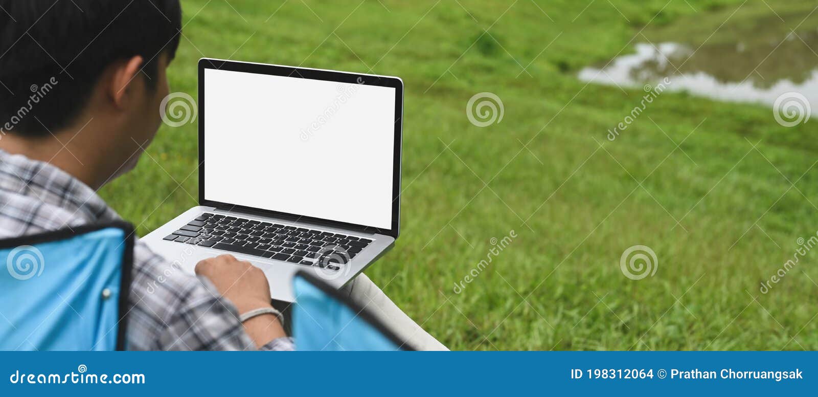 A Young Farmer is Using a Computer Laptop in a Green Yard. Stock Photo ...
