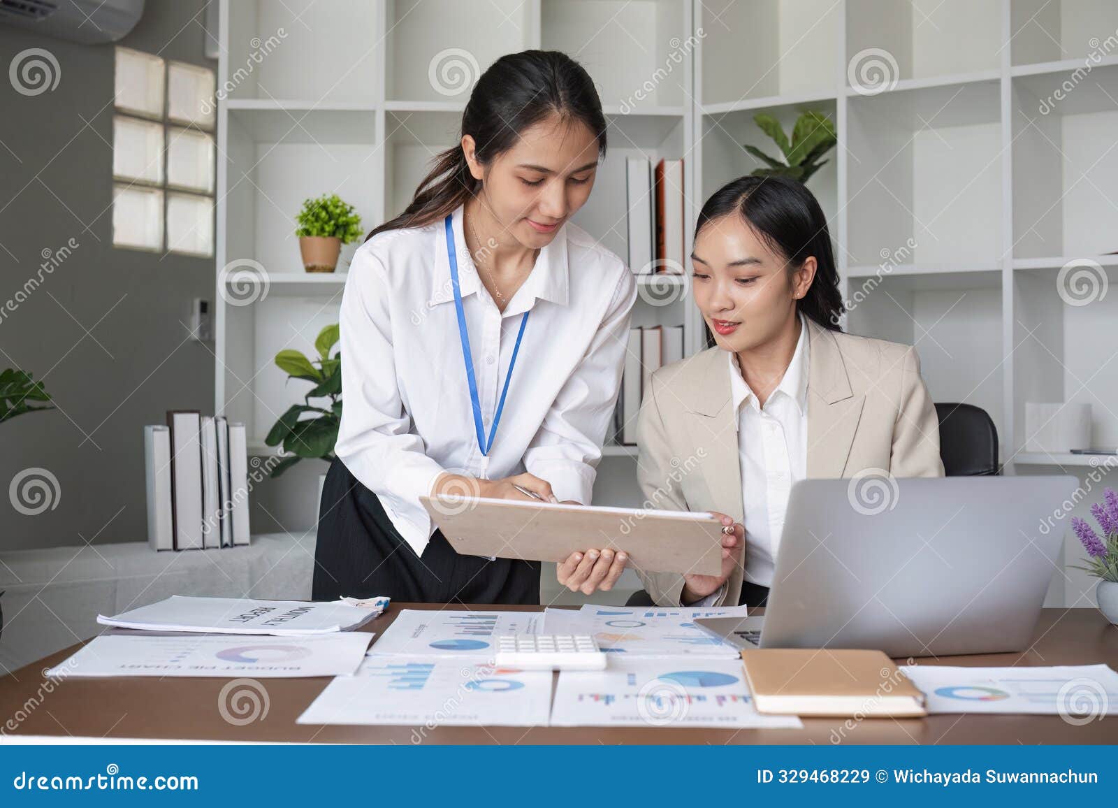 Female Accountants Use A Calculator To Sum Up The Amount Of Income ...