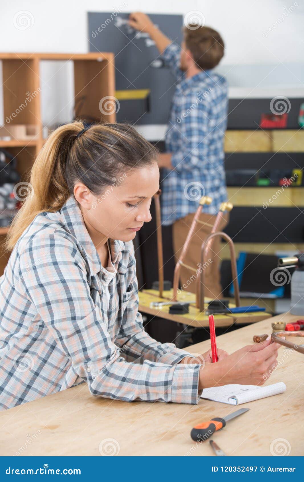 Young Female Carpenter Writing on Document in Workshop Stock Image ...