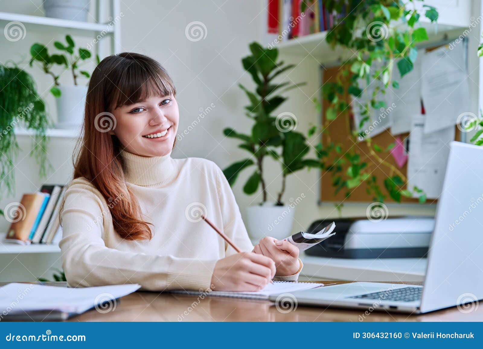 Young Female College Student Studying at Home Using Laptop, Writing in ...