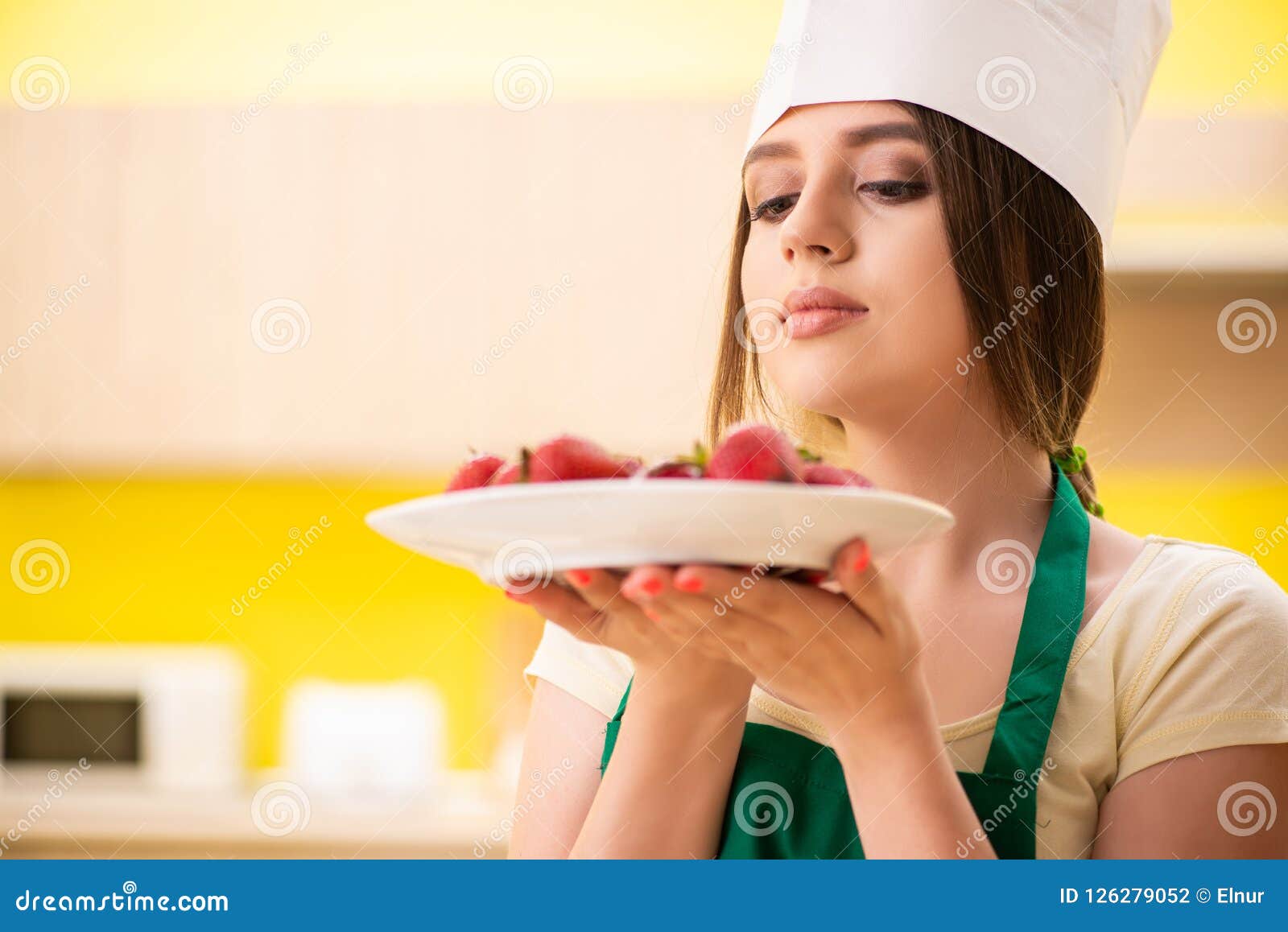 The Young Female Cook Eating Strawberries Stock Photo - Image of ...