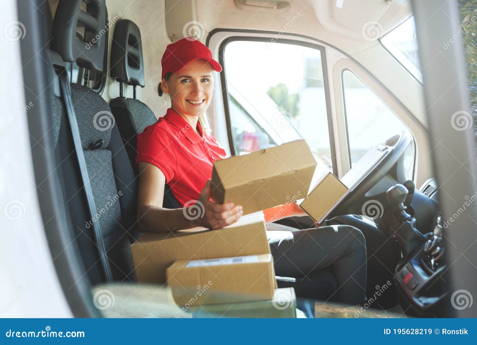 Female Delivery Service Worker in Red Uniform Sitting in Van with Boxes ...