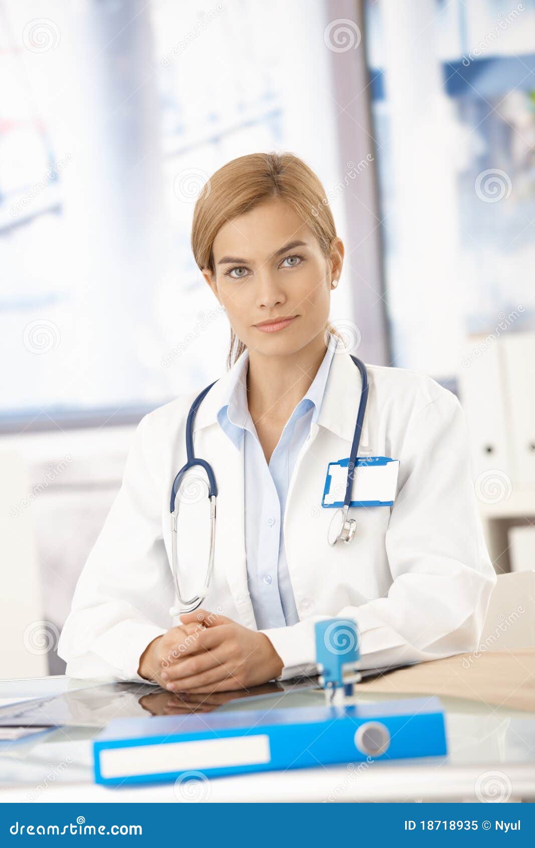 Young Female Doctor Sitting at Desk Stock Image - Image of doctor ...