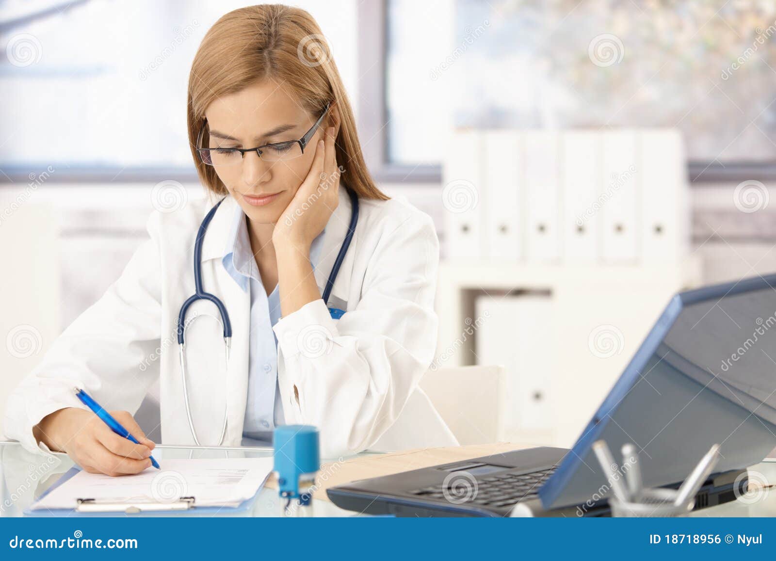 Young Female Doctor Sitting at Desk Working Stock Photo - Image of ...