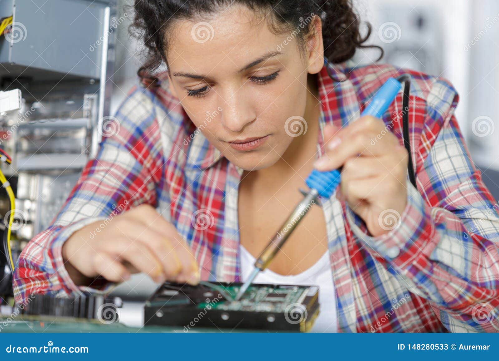 Young Female Electronic Engineer Soldering Computer Motherboard in ...