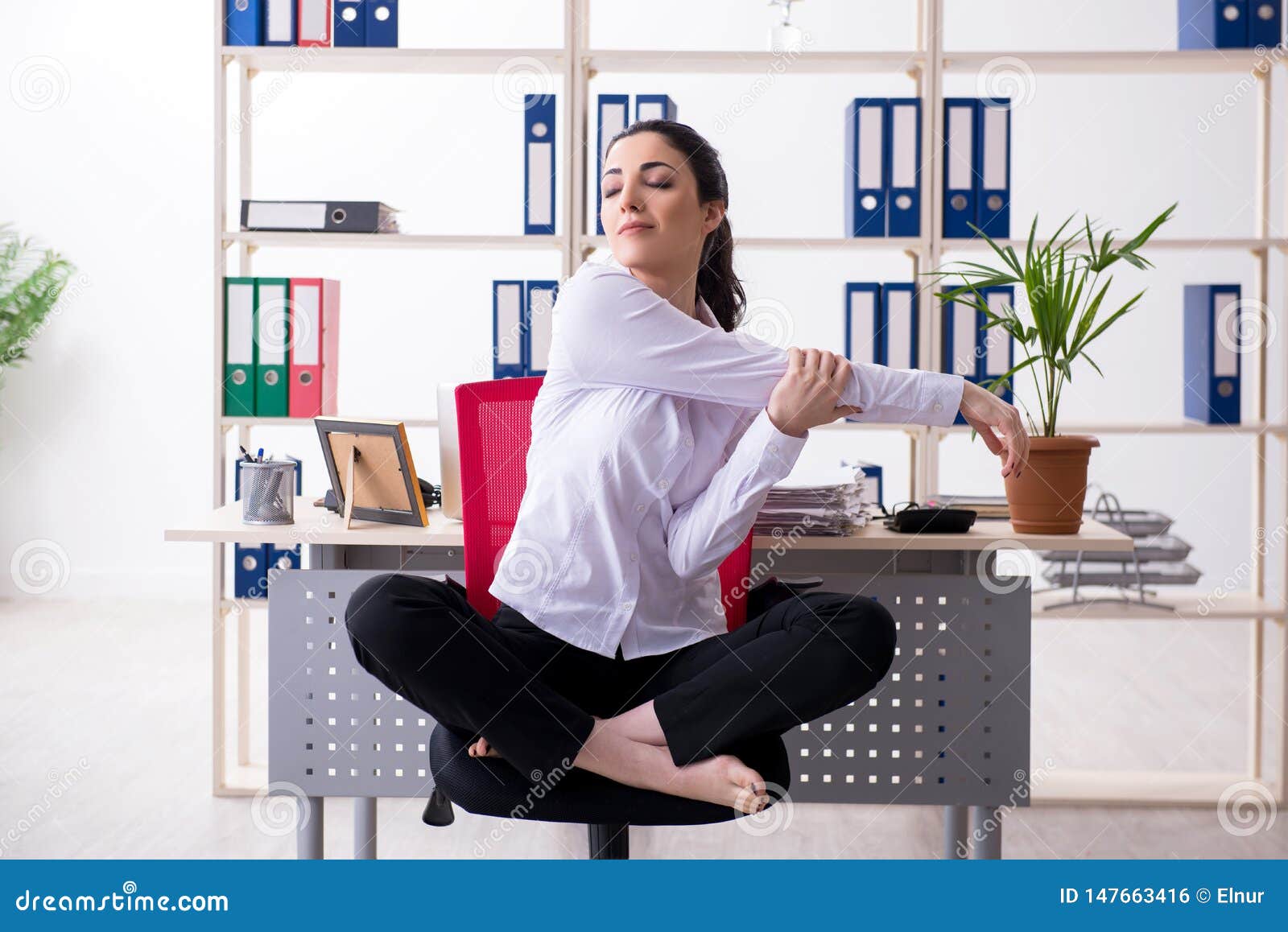 The Young Female Employee Doing Exercises in the Office Stock Photo ...