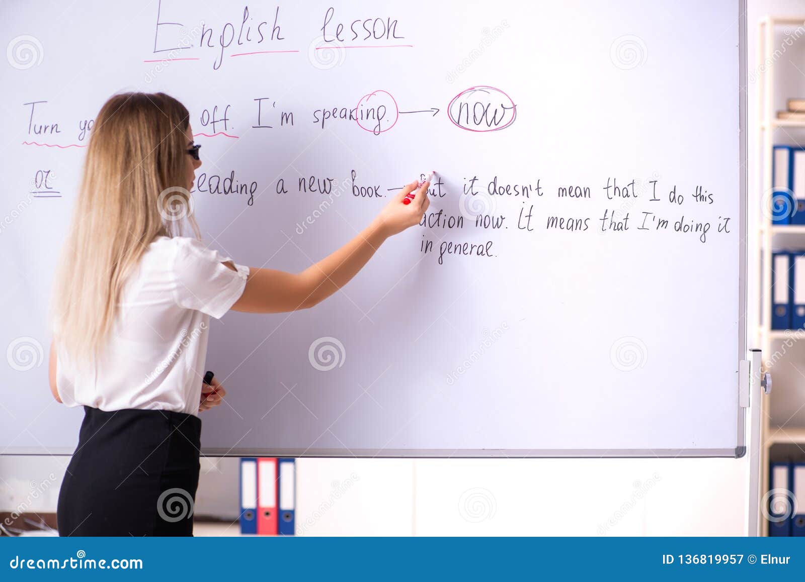 The Young Female English Language Teacher Standing in Front of the ...