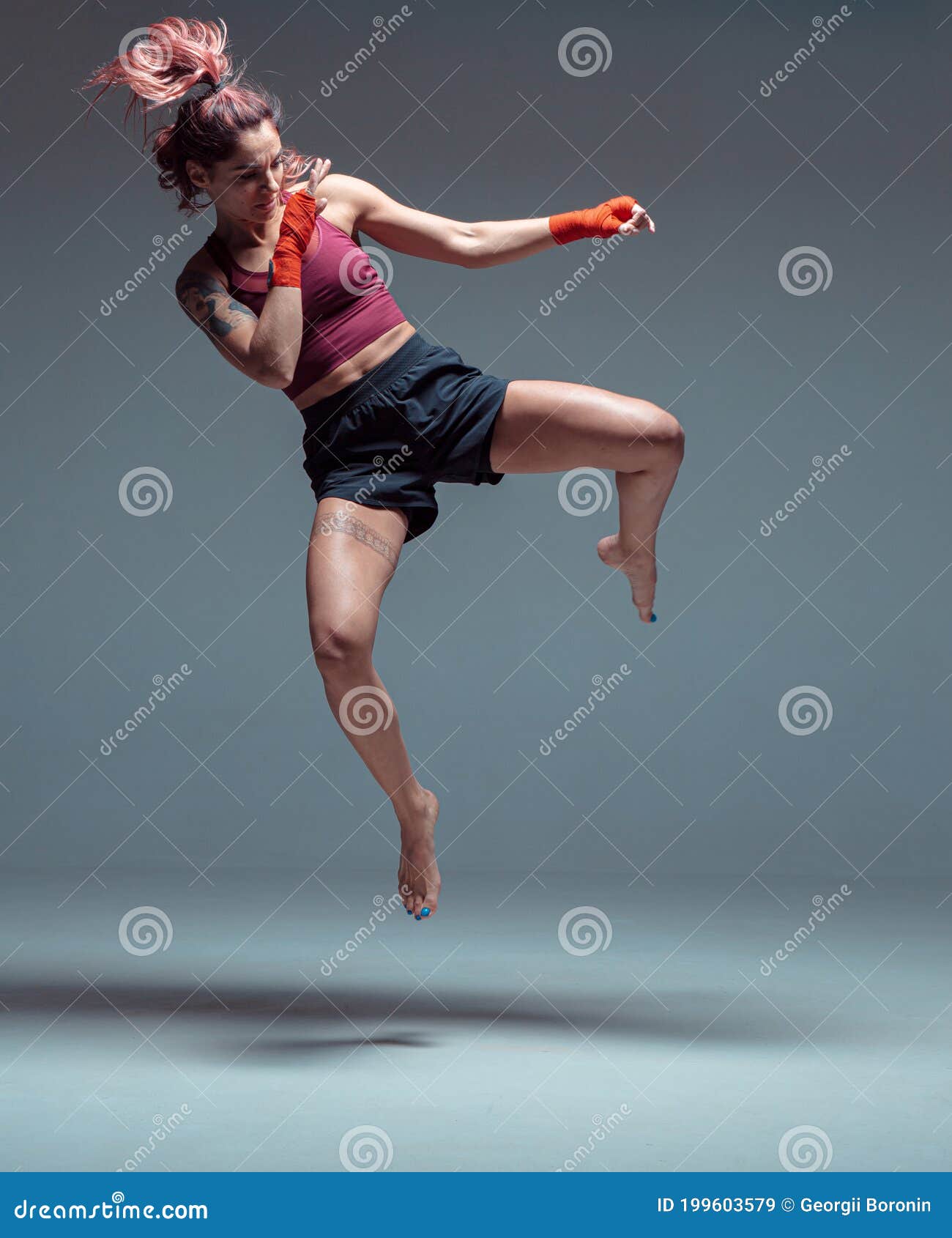 A Young Female Fighter Performs a Jump Kick. Stock Image - Image of ...