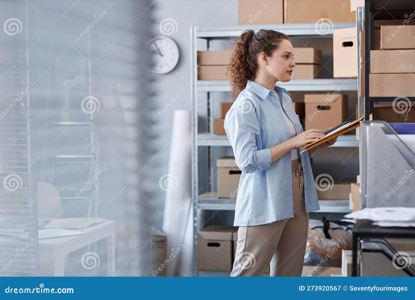 Young Female Manager with Tablet Standing in Front of Tall Rack Stock ...