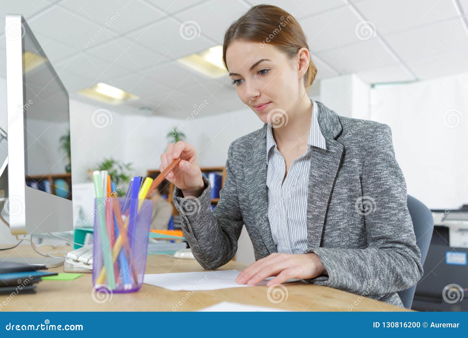 Young Female Office Worker at Computer Desk Sorting Pencils Stock Photo ...