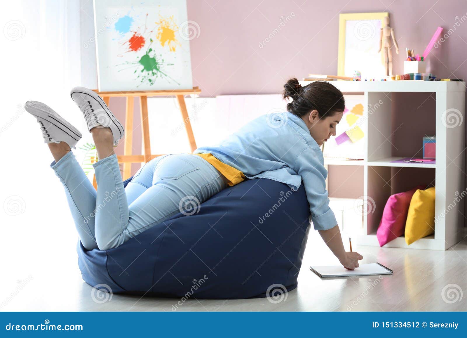 Young Female Painter on Beanbag Chair in Studio Stock Photo - Image of ...