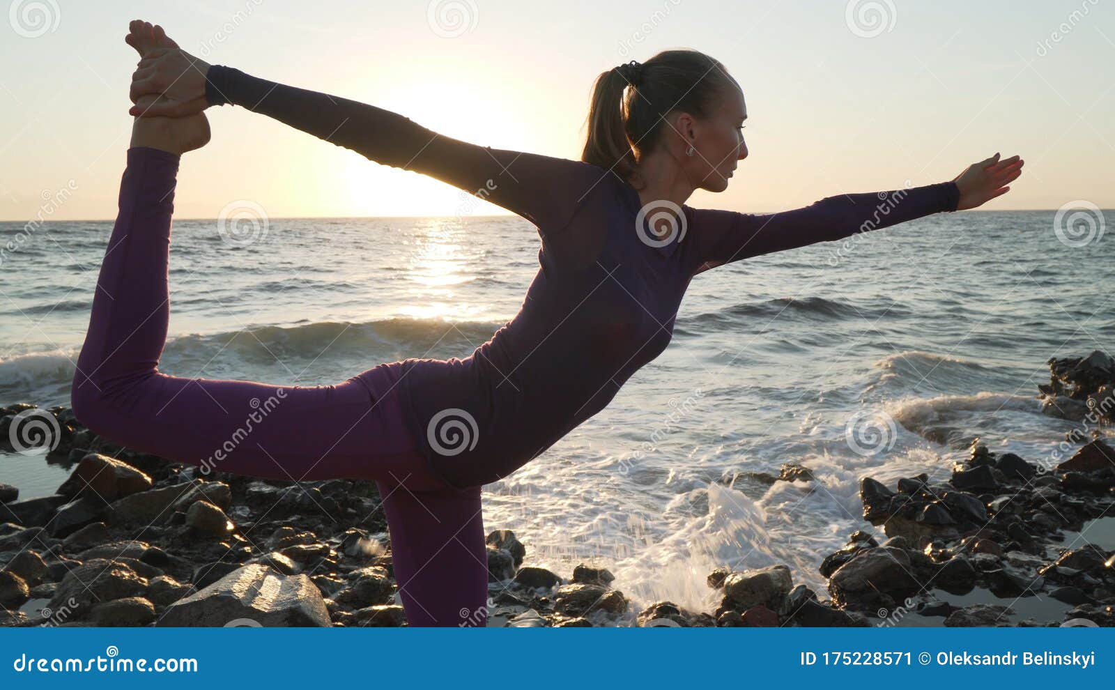 Young Female Performs a Standing Bow Pulling Yoga Pose at Seashore ...