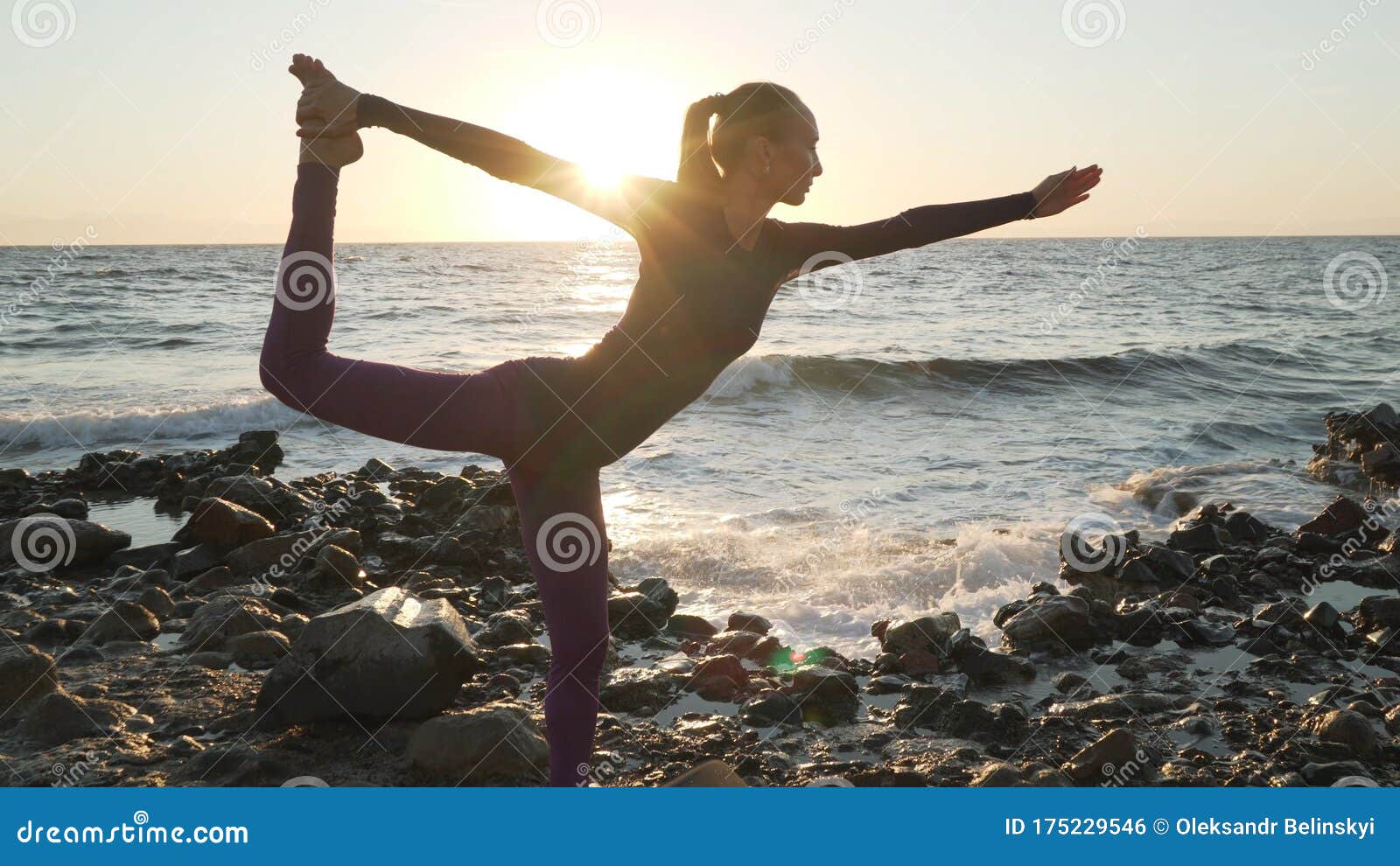 Young Female Performs a Standing Bow Pulling Yoga Pose at Seashore ...
